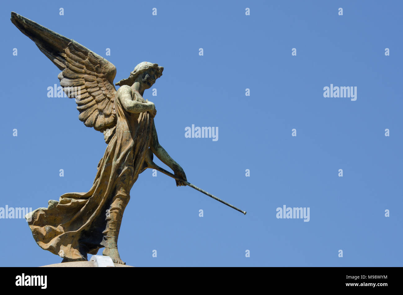 Stone female angel with wings raised looking down. Female angel in ...
