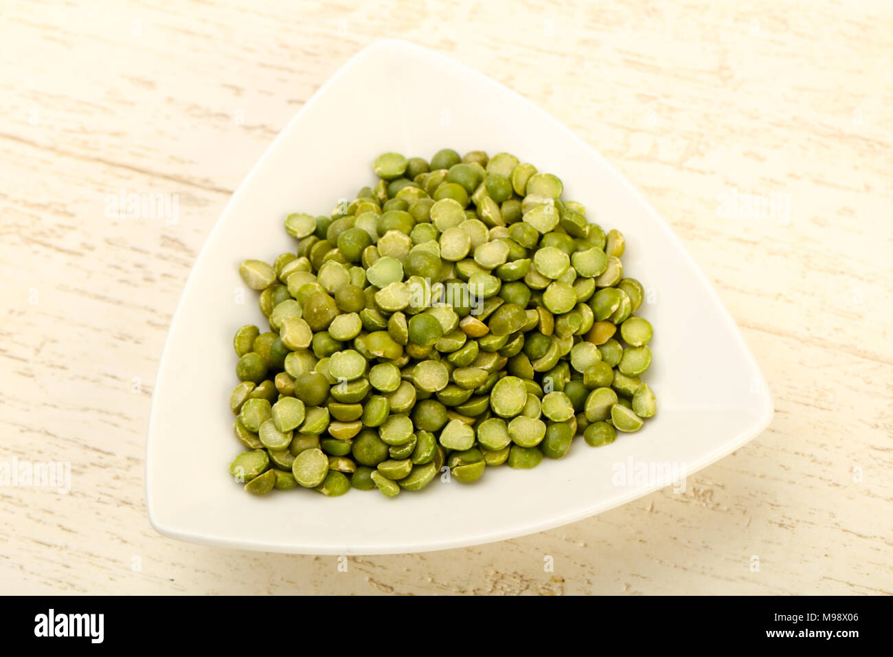 Green peas pile in the bowl over wooden background Stock Photo - Alamy