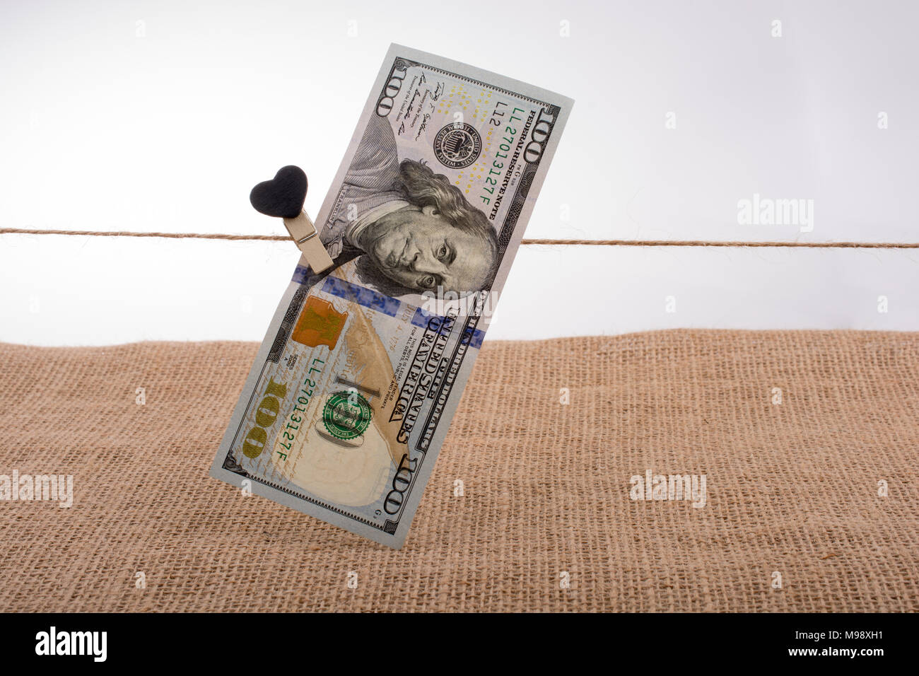 American 100 dollar banknotes with a heart clip on a string Stock Photo ...