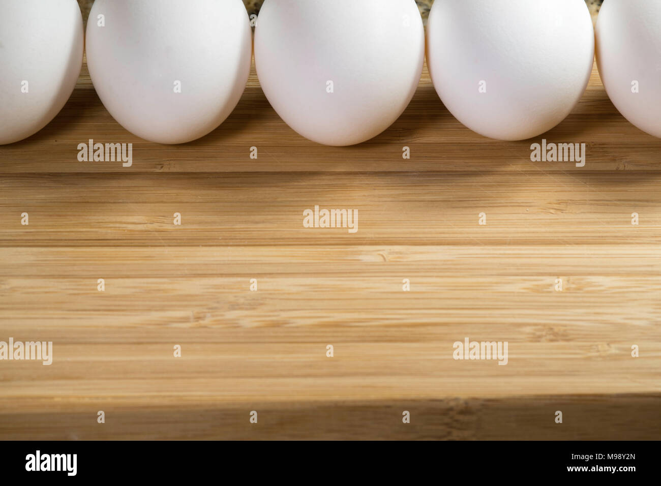 fresh white egg border on a bamboo cutting board Stock Photo - Alamy
