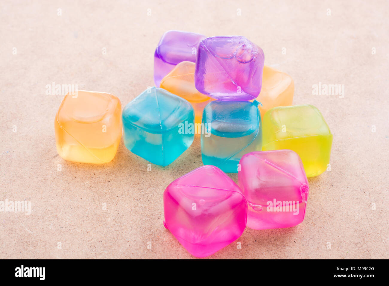 Fake colorful ice cubes on a brown background Stock Photo - Alamy