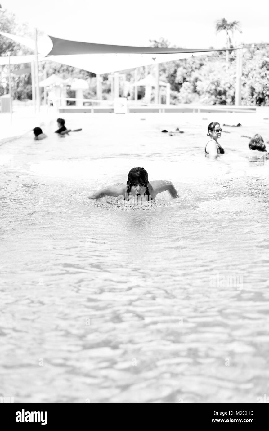 Woman swimming butterfly in a swimming lane at a public pool with other ...