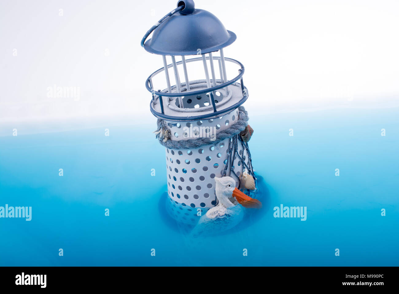 Little model lighthouse placed in blue water Stock Photo - Alamy