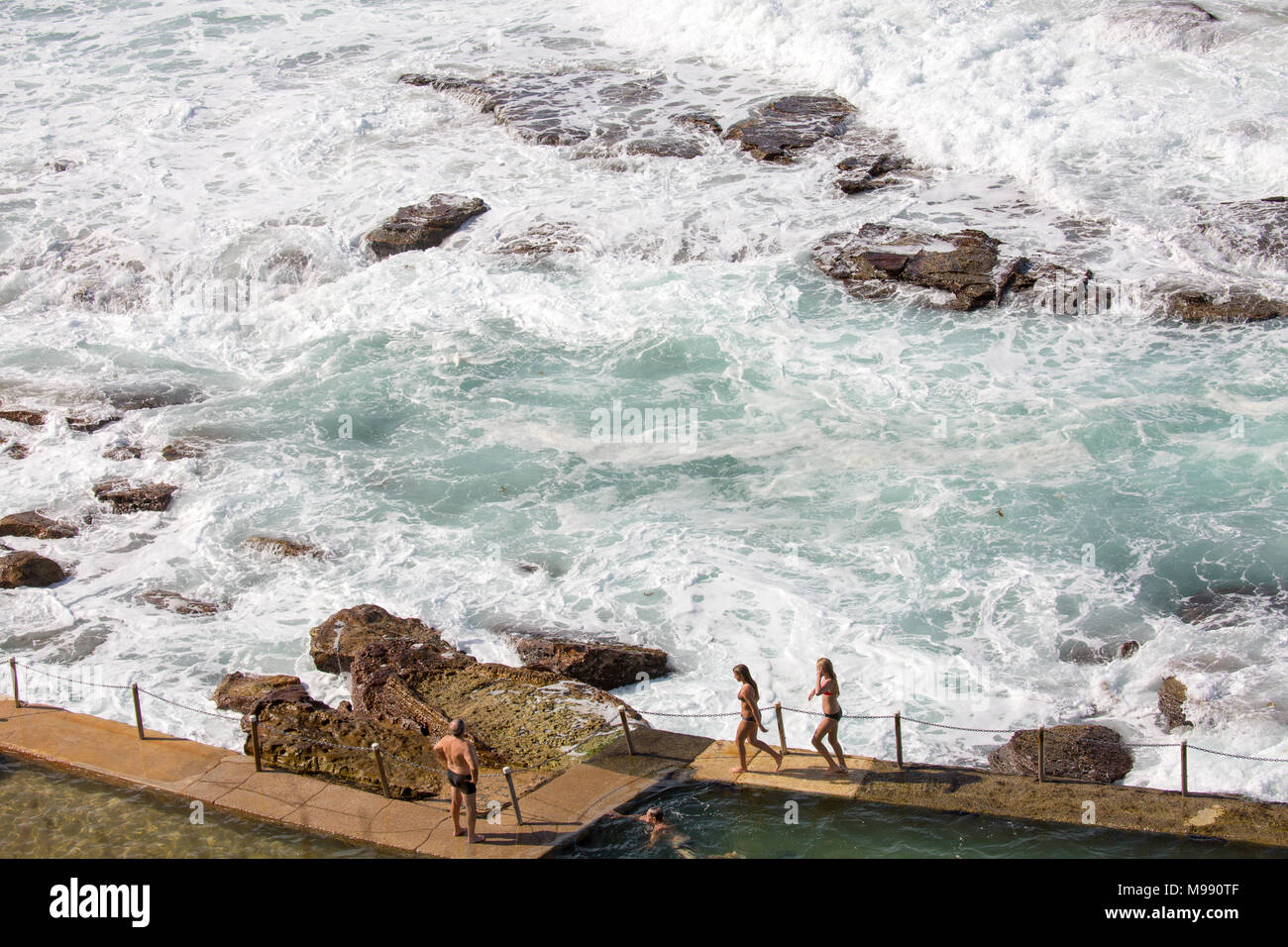 People walking around the man made ocean swimming pool at Avalon Beach ...