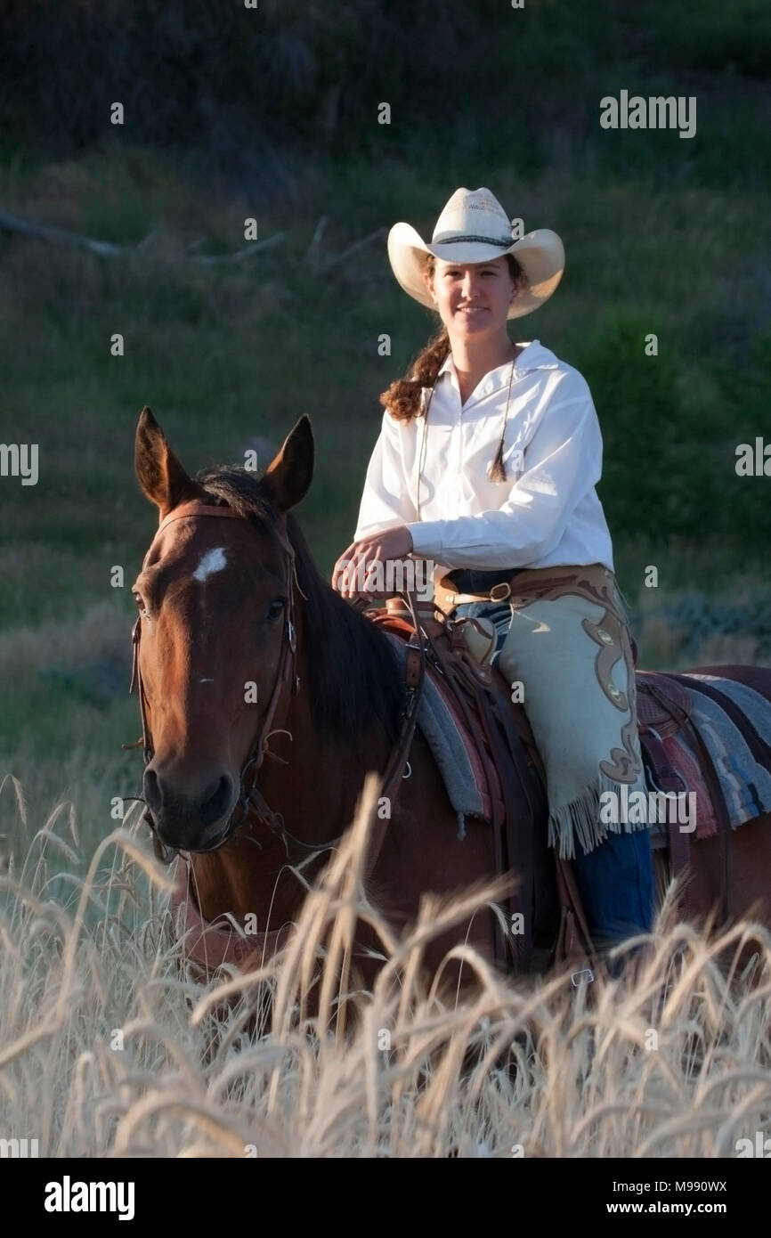 Cowgirl and horse trainer riding on horseback in the countryside Stock ...