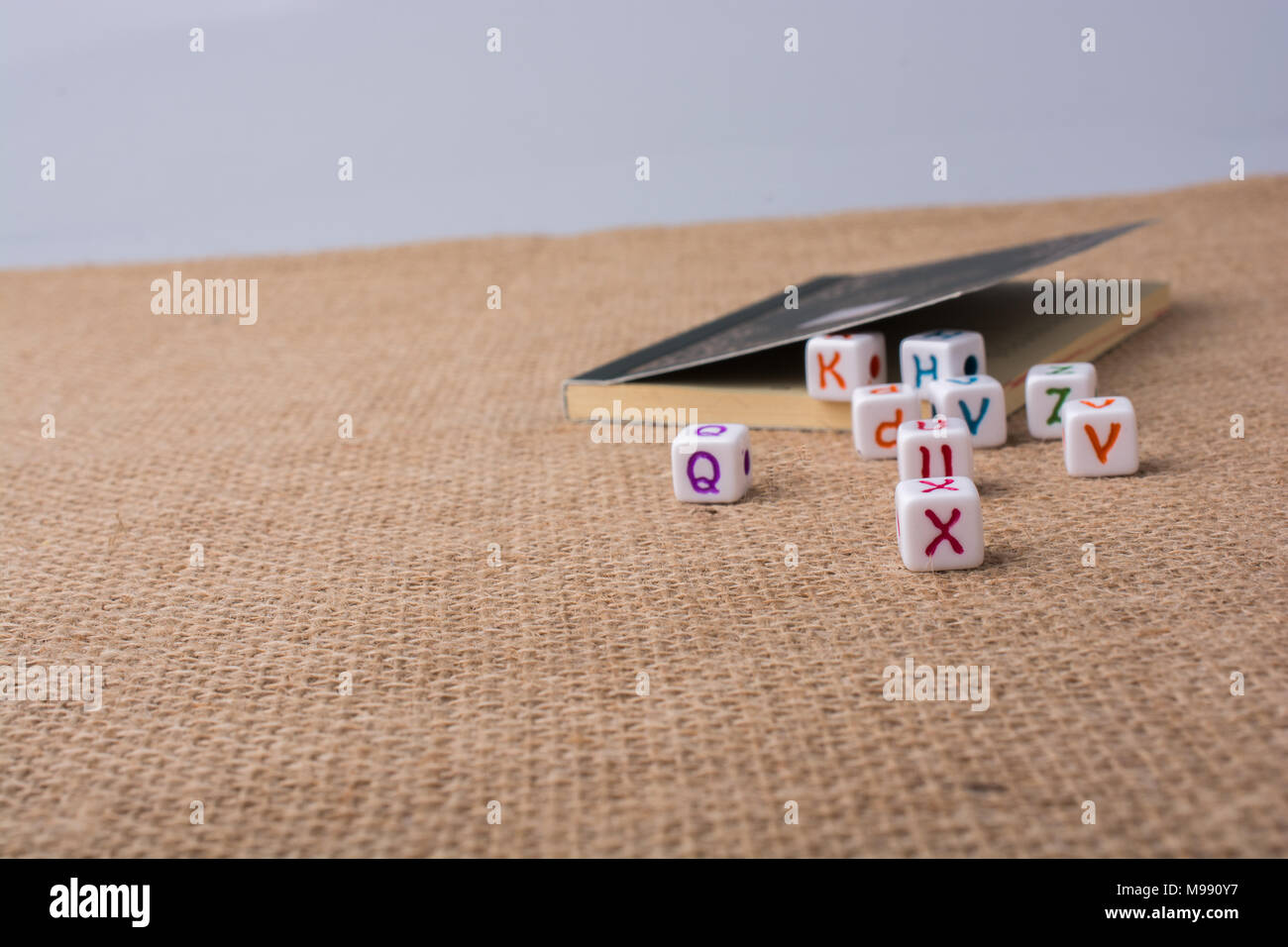 Colorful alphabet letter cubes out of sack on a canvas Stock Photo - Alamy