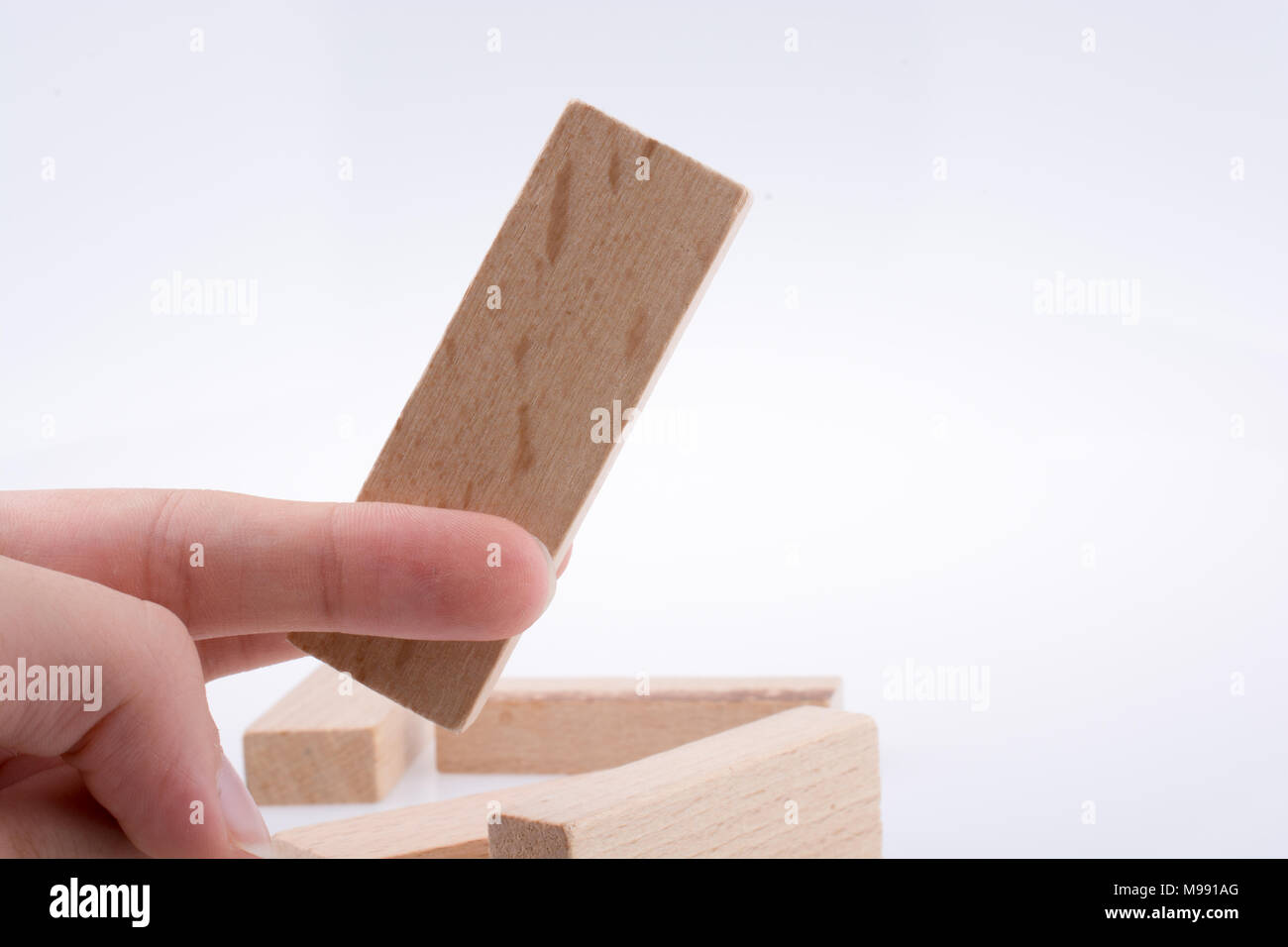 Hand playing with wooden building blocks on white background Stock ...