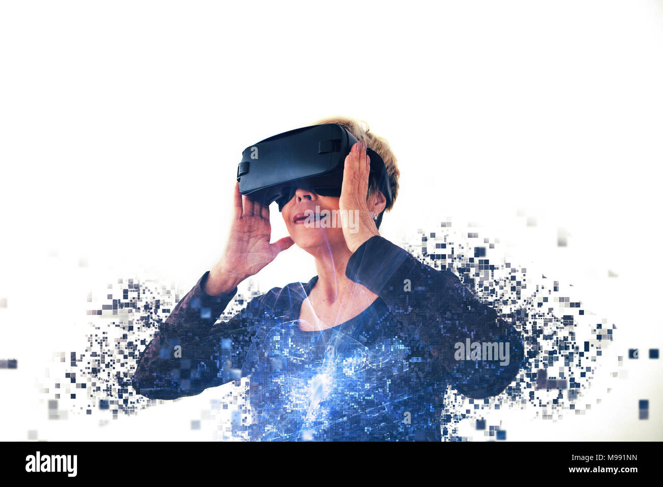 An elderly woman in virtual reality glasses is scattered by pixels ...