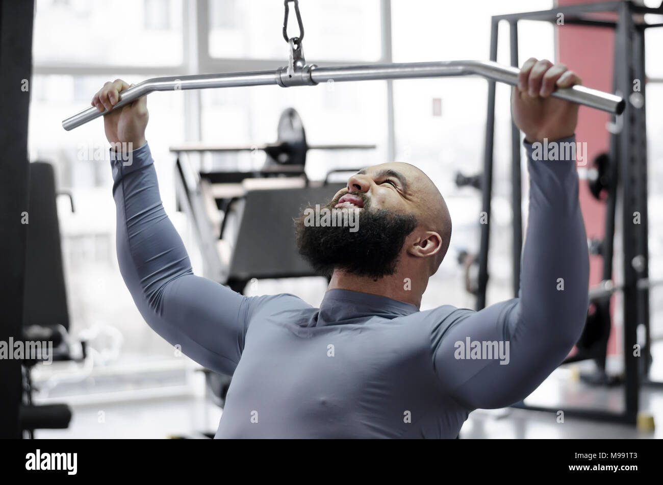 Male athlete pulling down heavy weight with strained face, sports ...