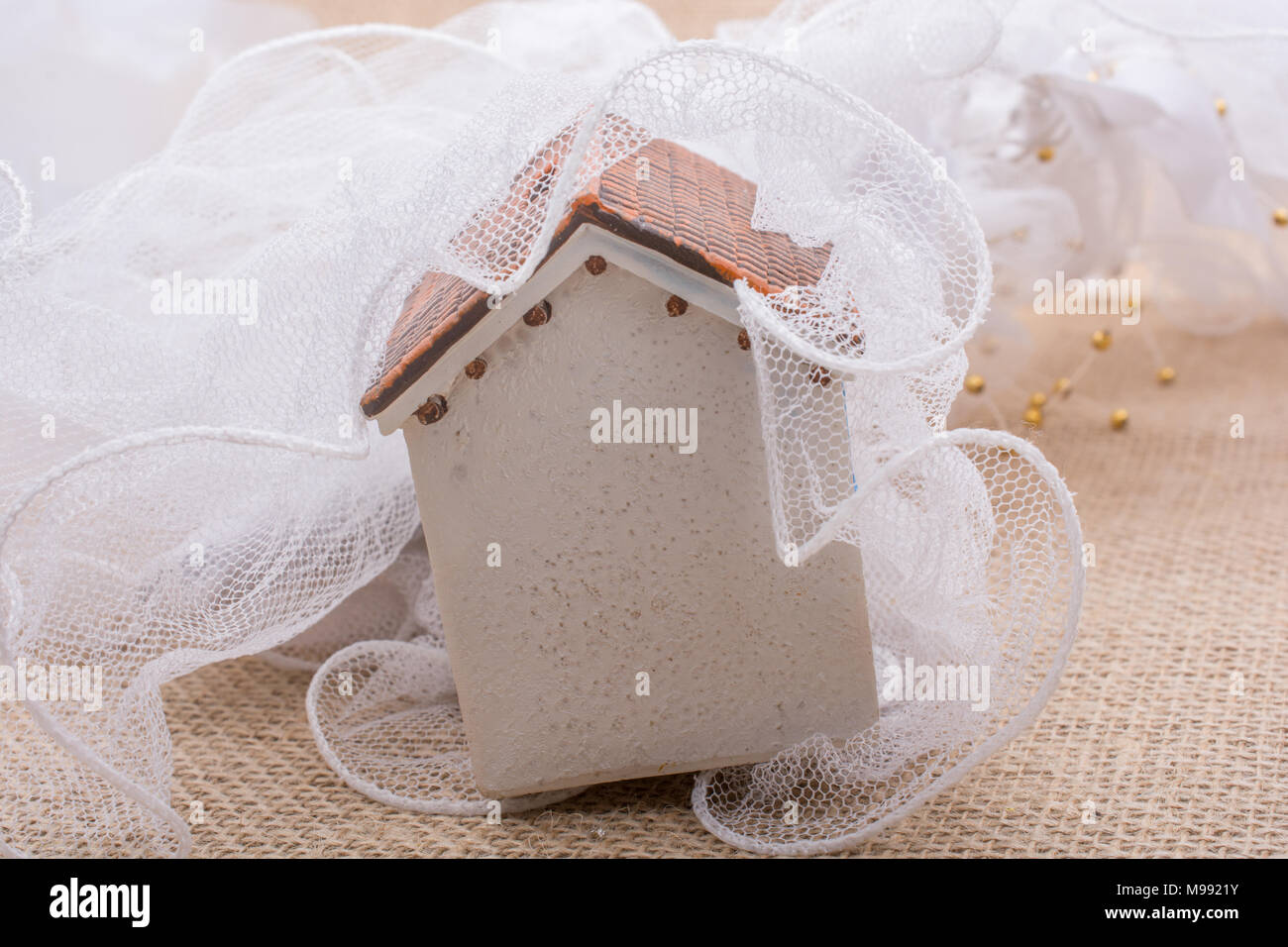 Little model house wrapped in cloth on a brown background Stock Photo ...
