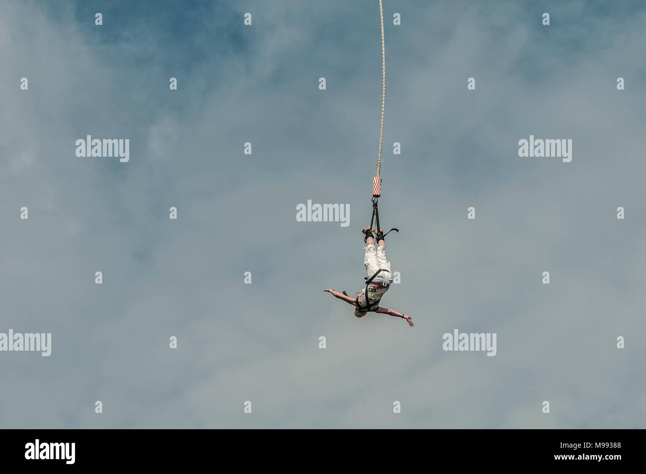 a woman is hanging high in the air attached to a cable Stock Photo - Alamy
