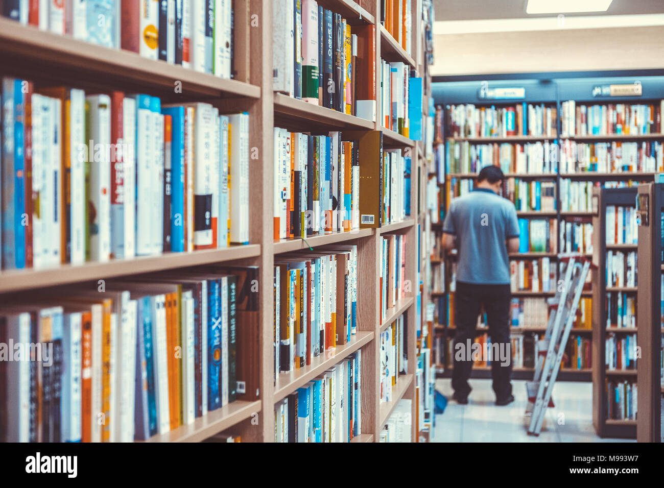 SEOUL, KOREA - AUGUST 13, 2015: Man checking out books in a bookstore ...