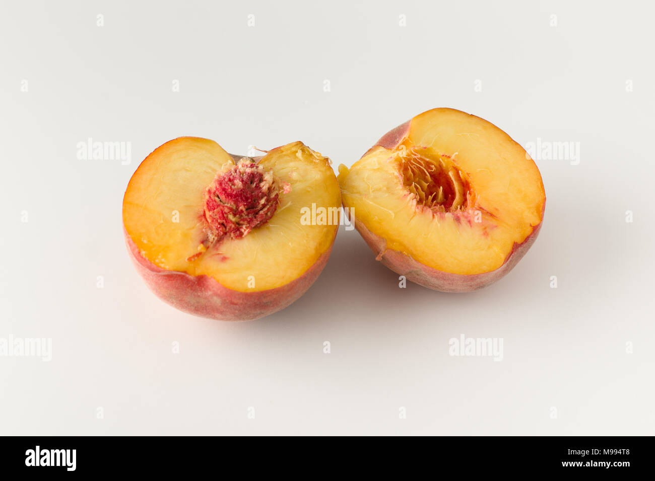 Fresh dissected peach with stone on white background Stock Photo - Alamy