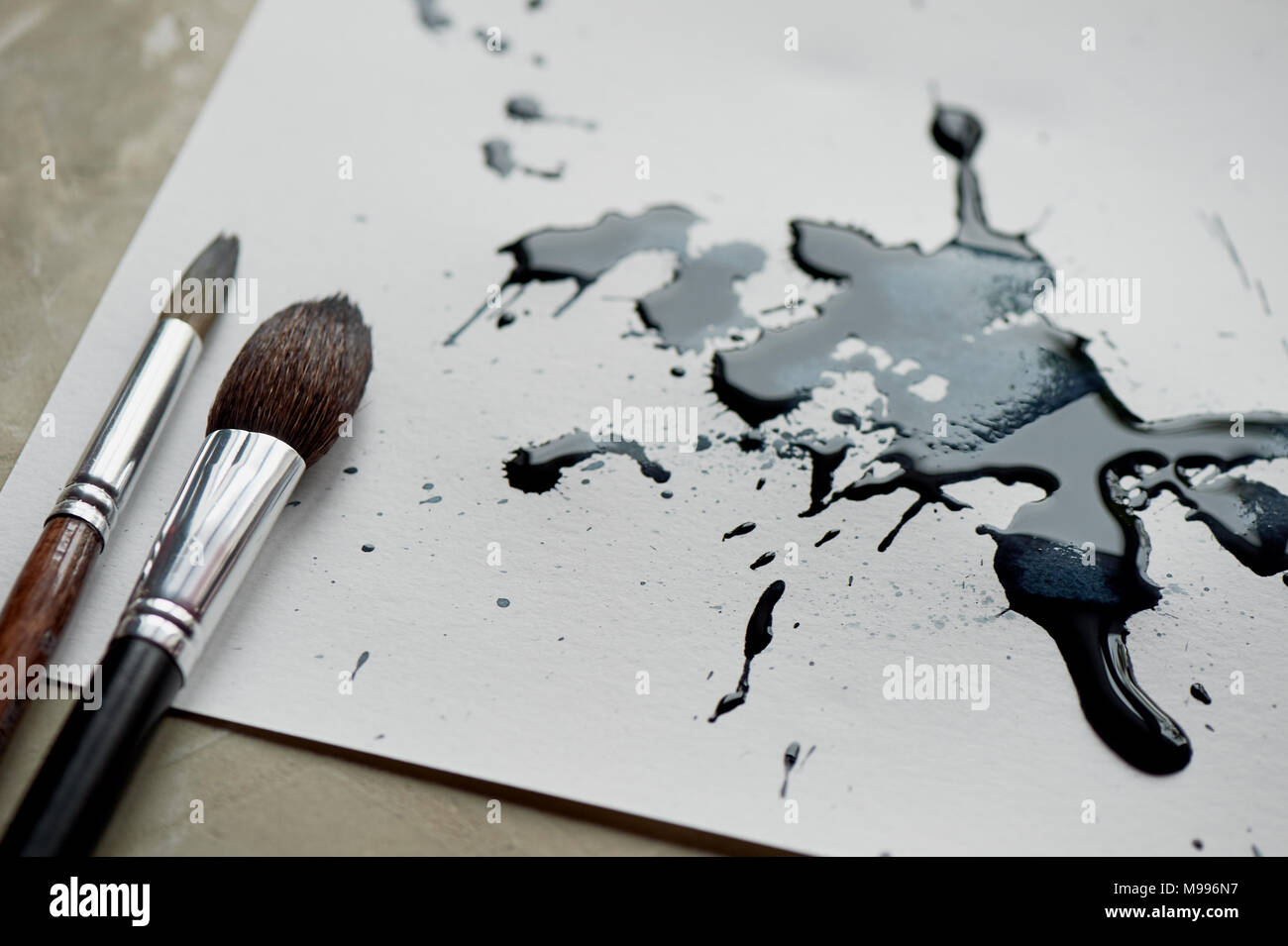 sheet of white paper with black artistic blots made by ink Stock Photo ...