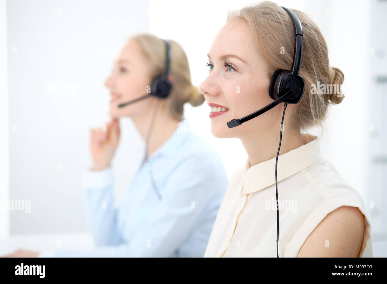 Image of bright call center. Focus on young beautiful woman in a ...