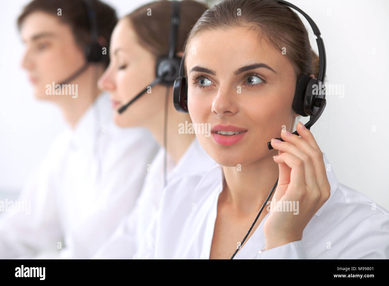 Call center. Focus on beautiful woman in headset Stock Photo - Alamy