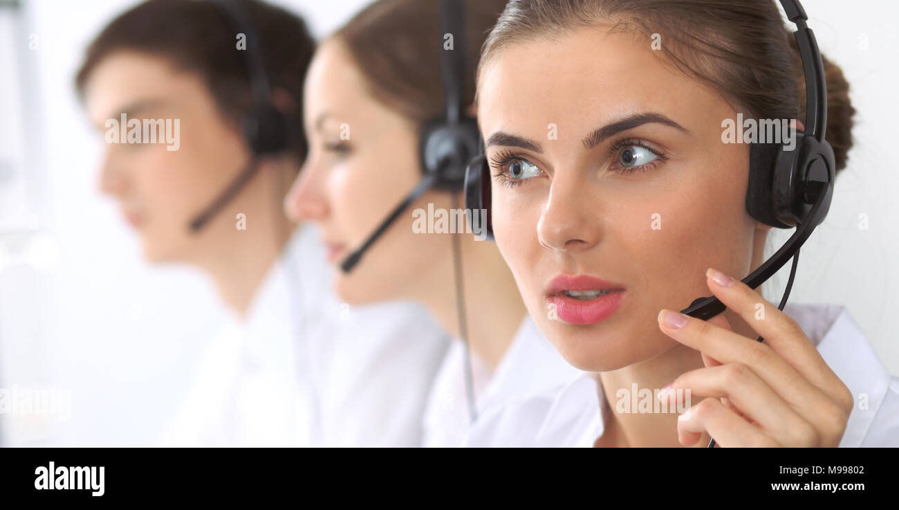 Call center. Focus on beautiful woman in headset Stock Photo - Alamy