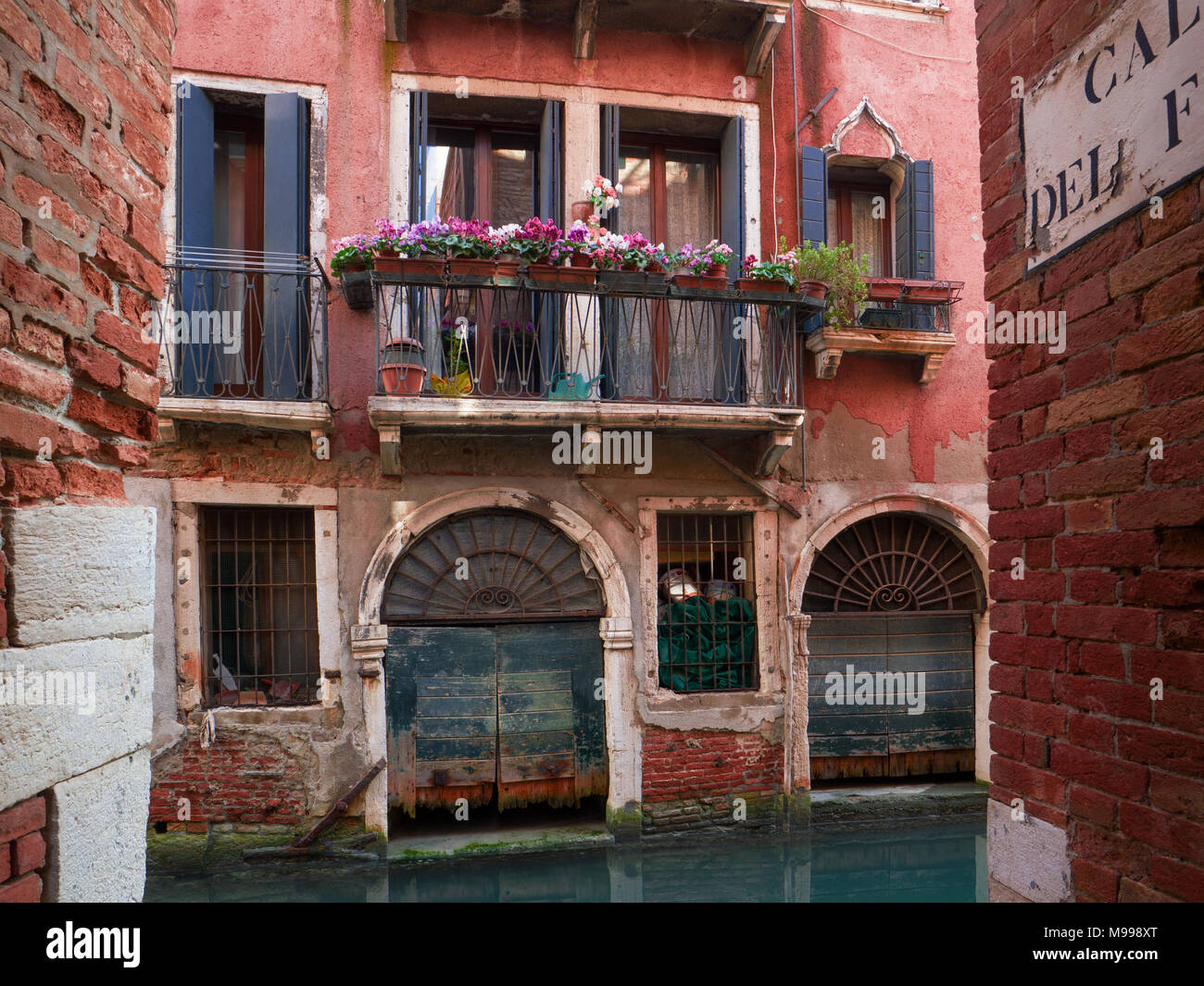 facade of an ancient Venetian palace overlooking a small romantic canal ...