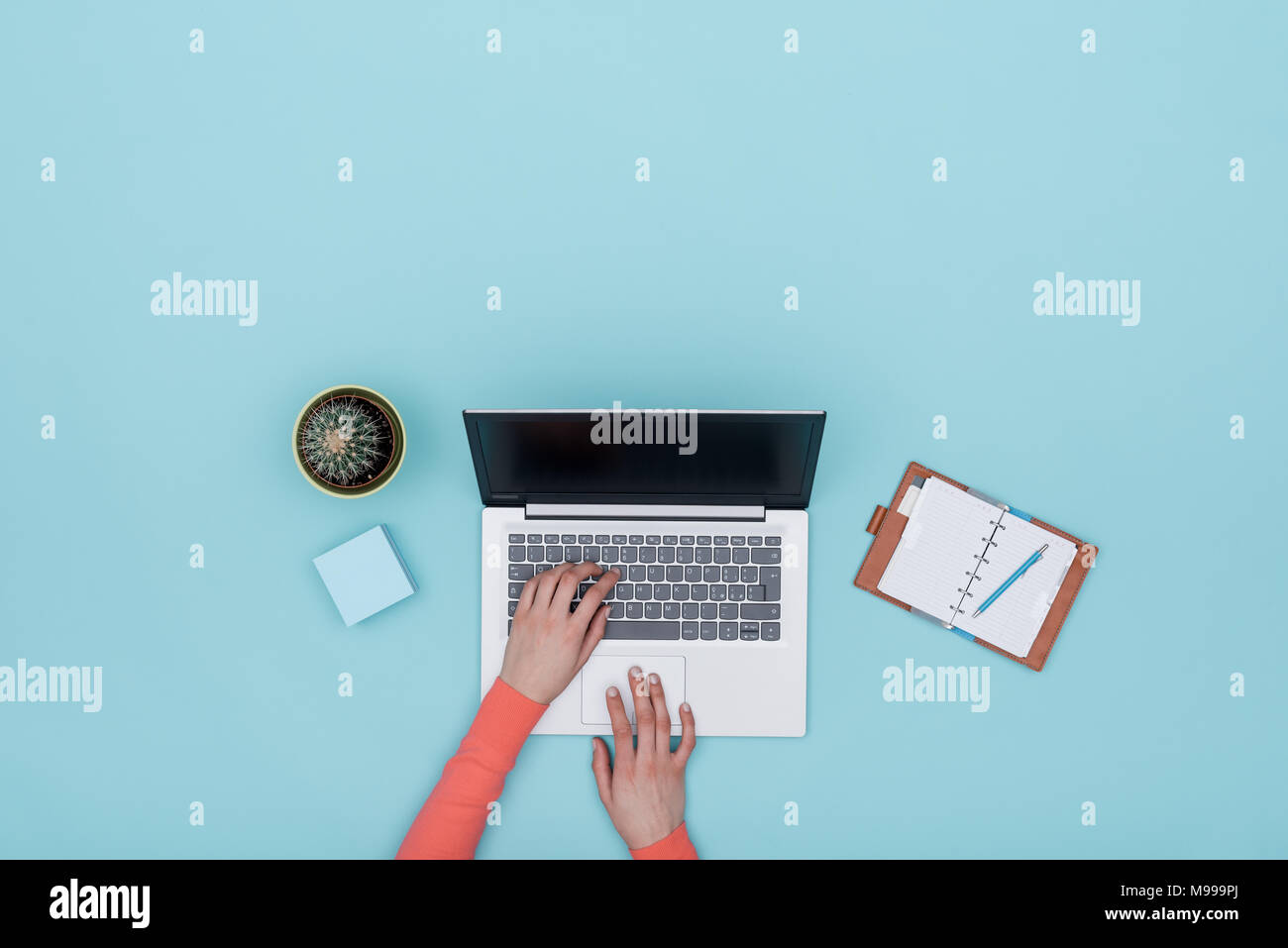 Minimalist light blue workspace with laptop, organizer and woman ...