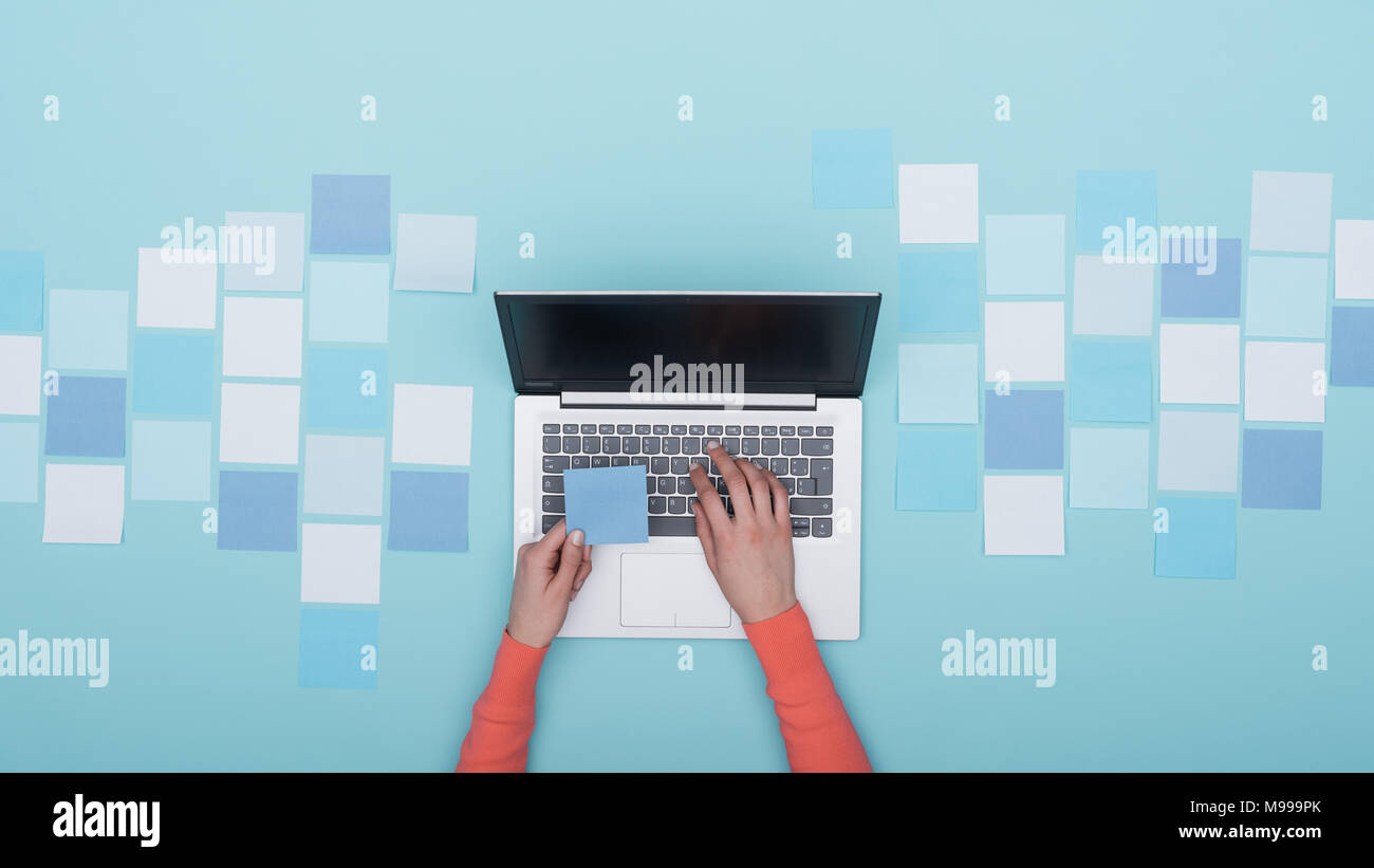 Woman working with her laptop and mosaic of sticky notes, she is ...