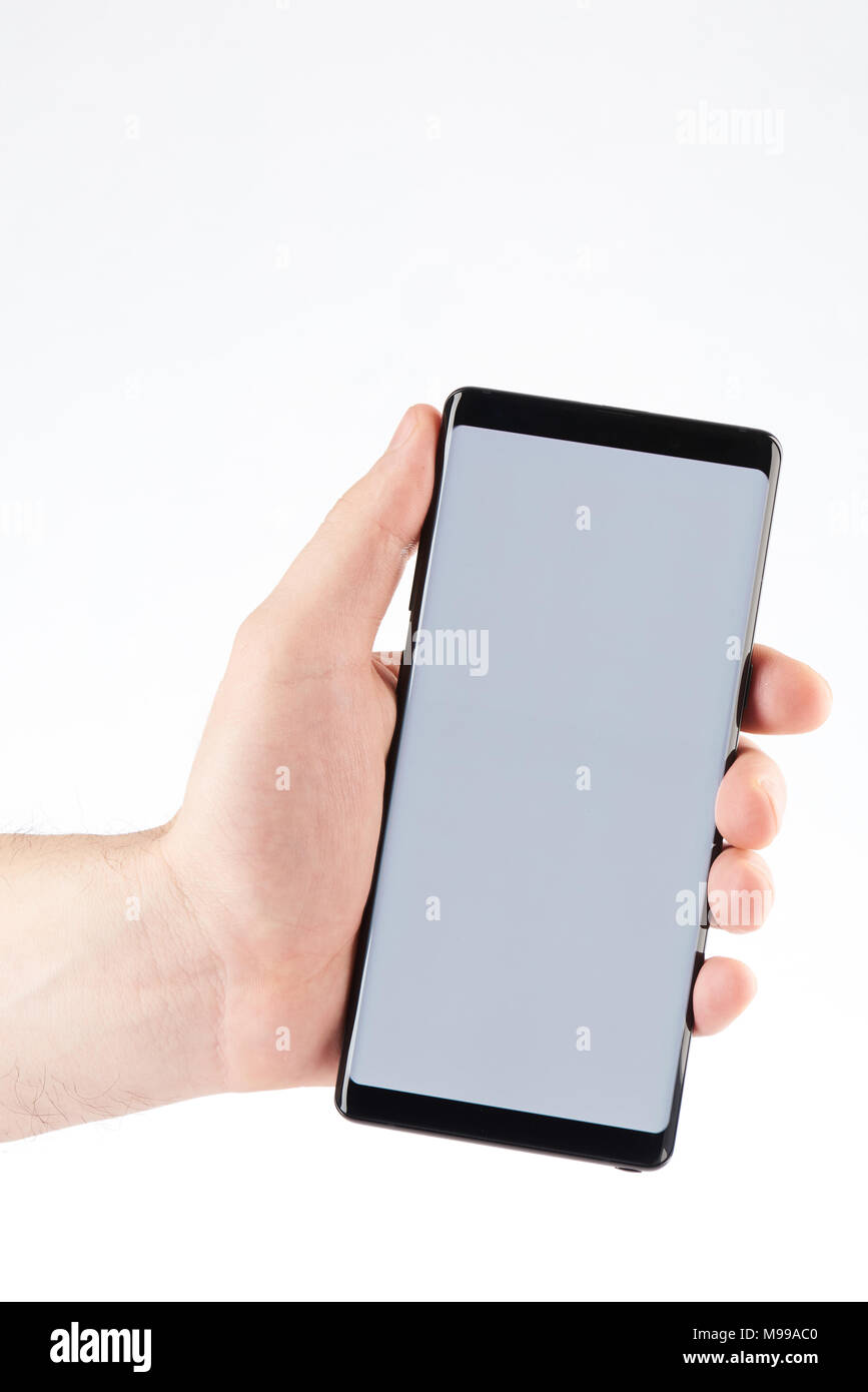 Smartphone with big screen in hand close-up isolated on white ...