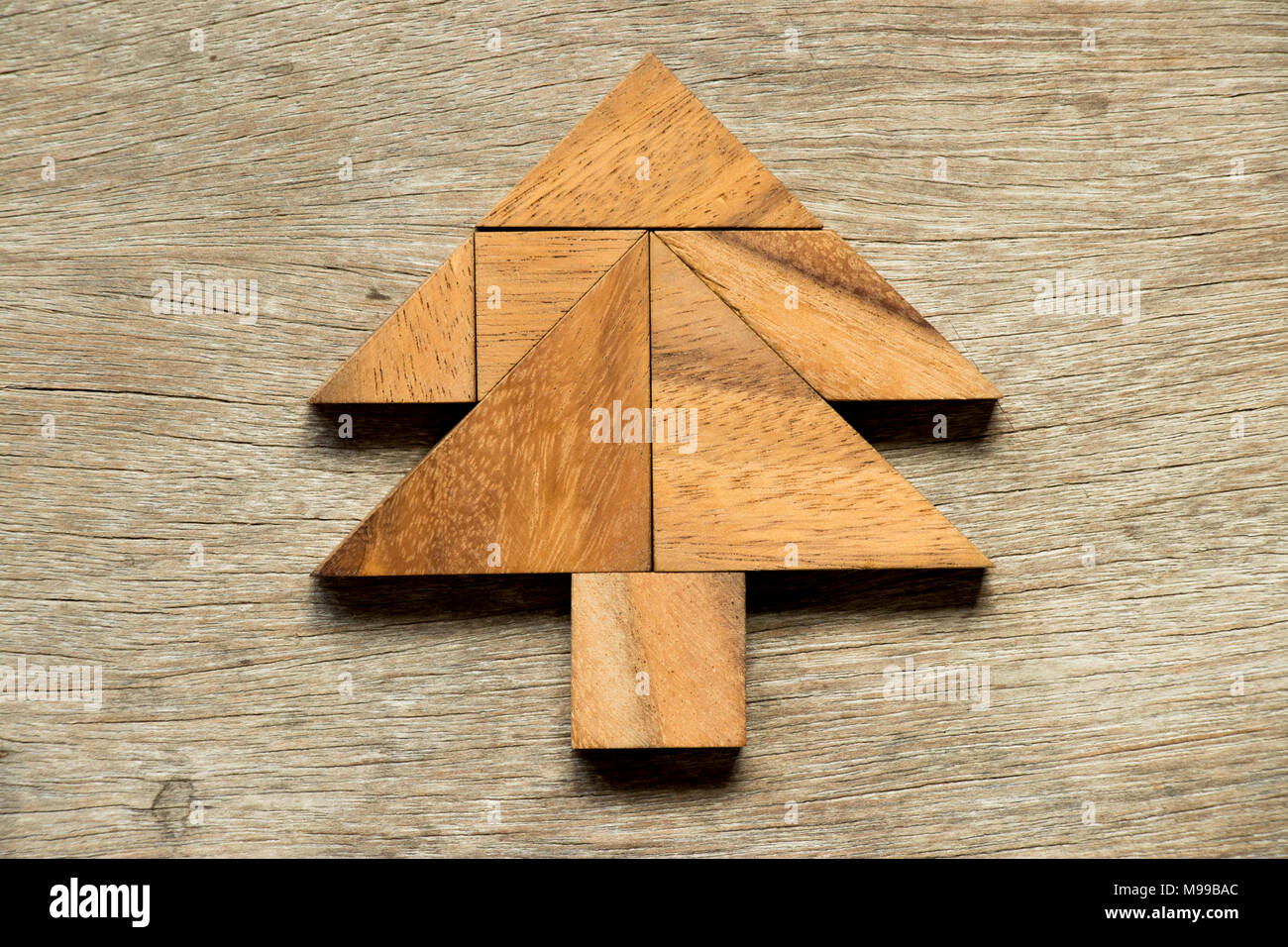 Tangram puzzle in christmas tree shape on wood background Stock Photo ...