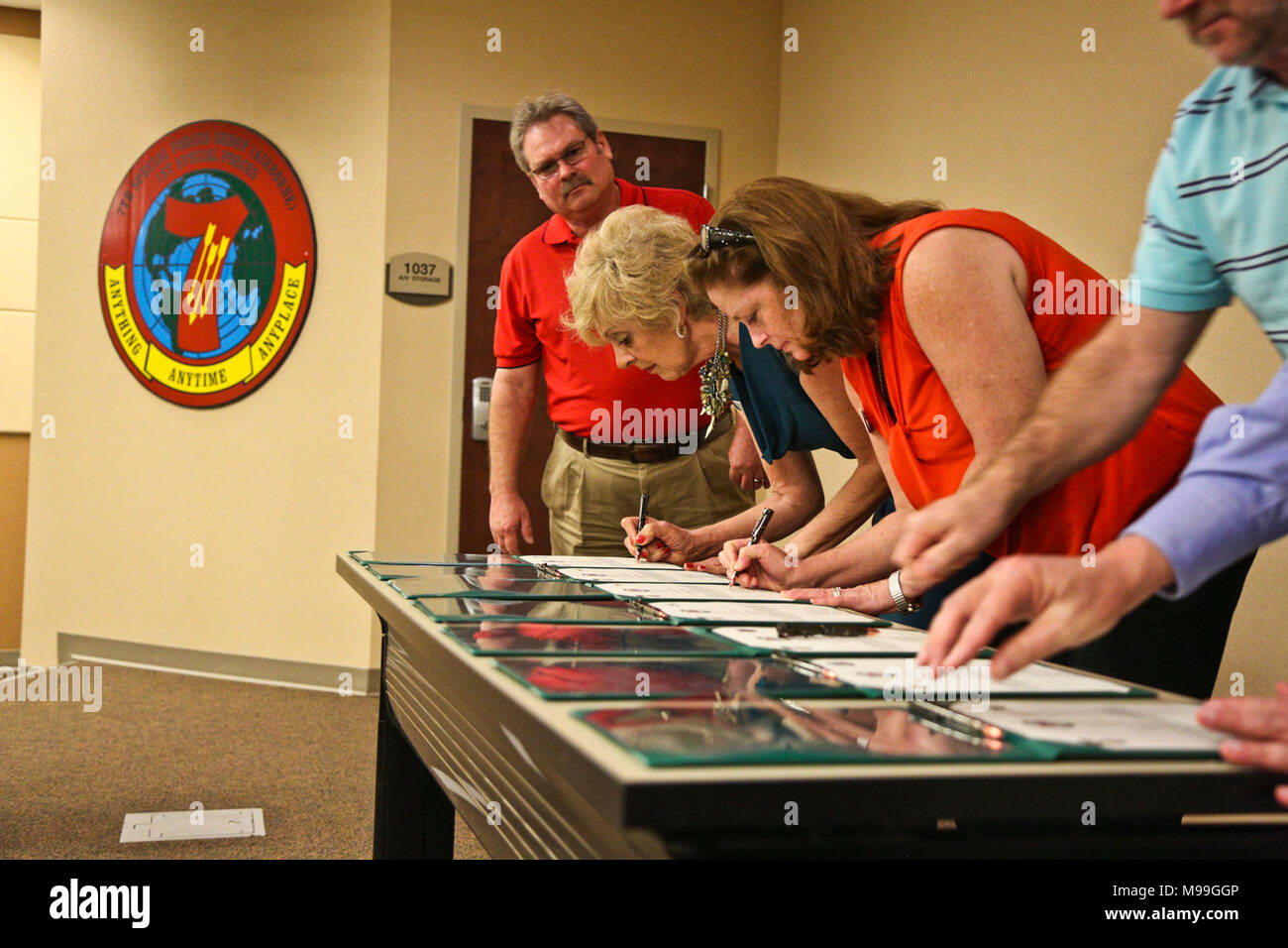 Newly inducted honorary commanders sign their certificates of duty at ...