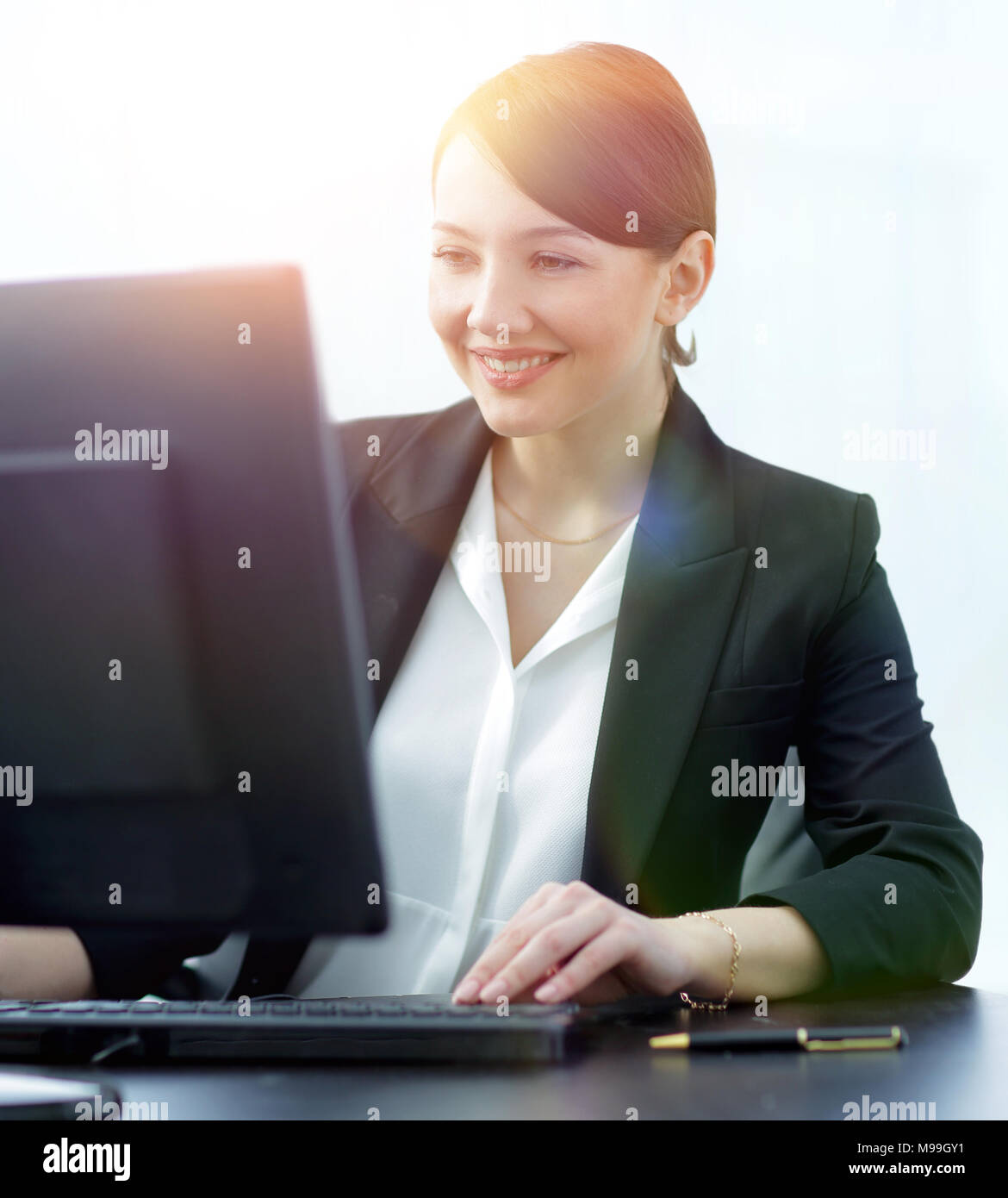 Happy businesswoman typing on computer at her desk Stock Photo - Alamy