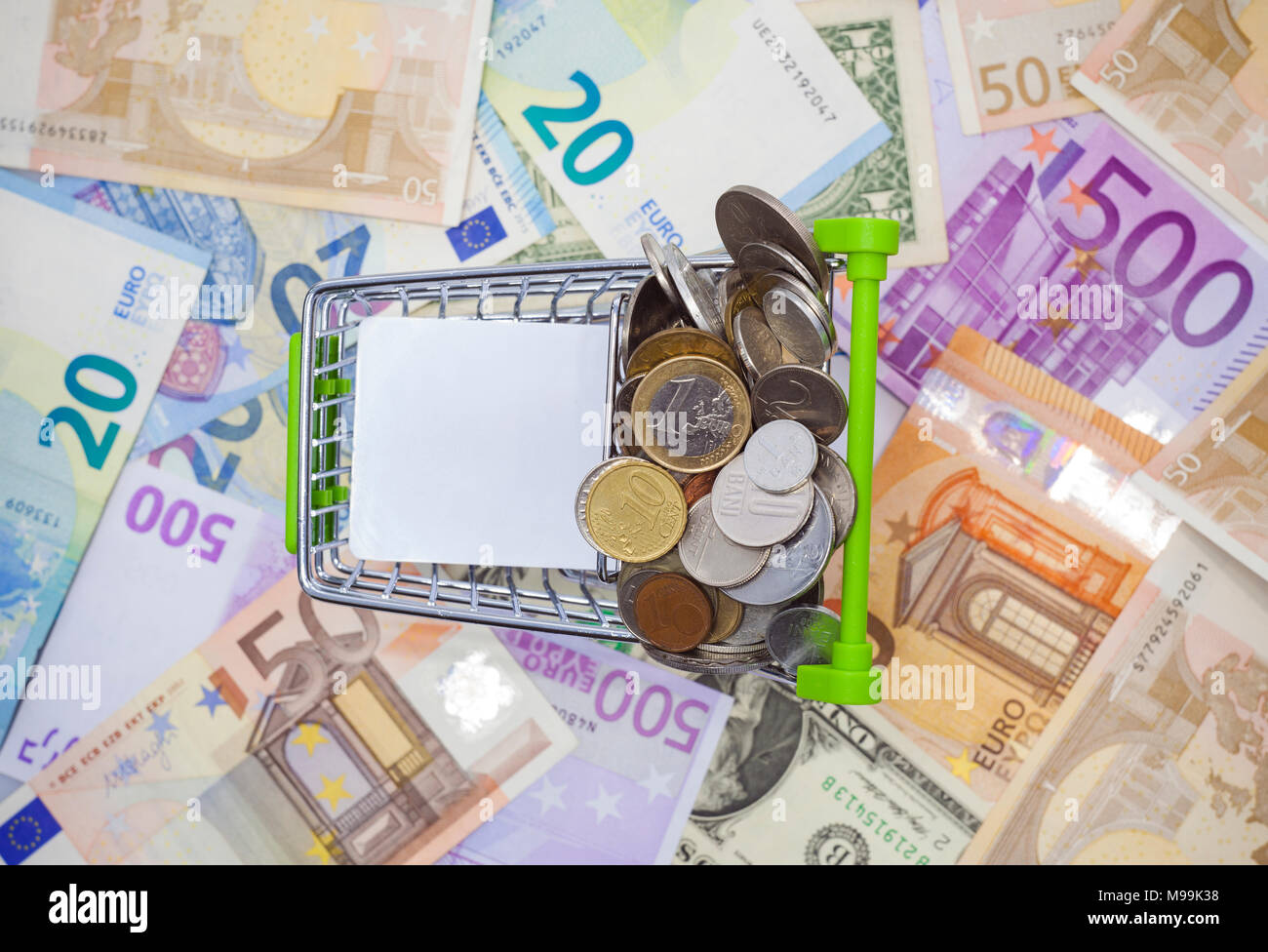shopping cart with coins and banknotes in background. white board for ...