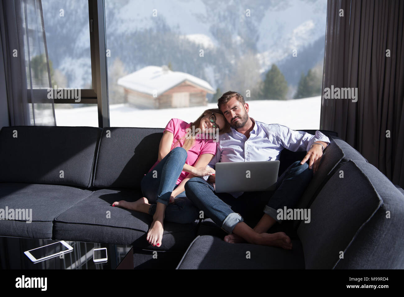 Young couple relaxing at home using laptop computers reading in the ...