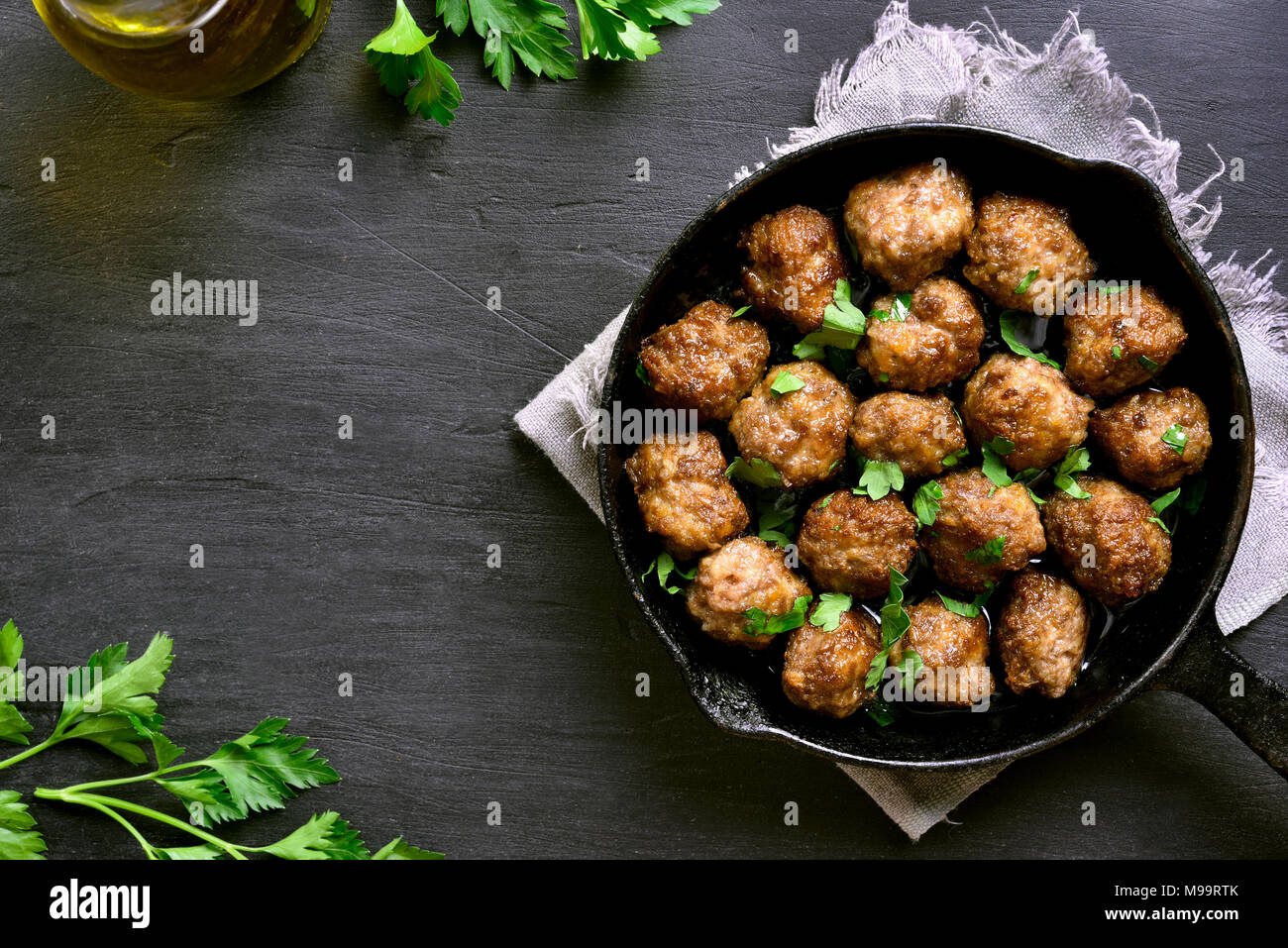 Meatballs in frying pan on black stone background with copy space. Top ...