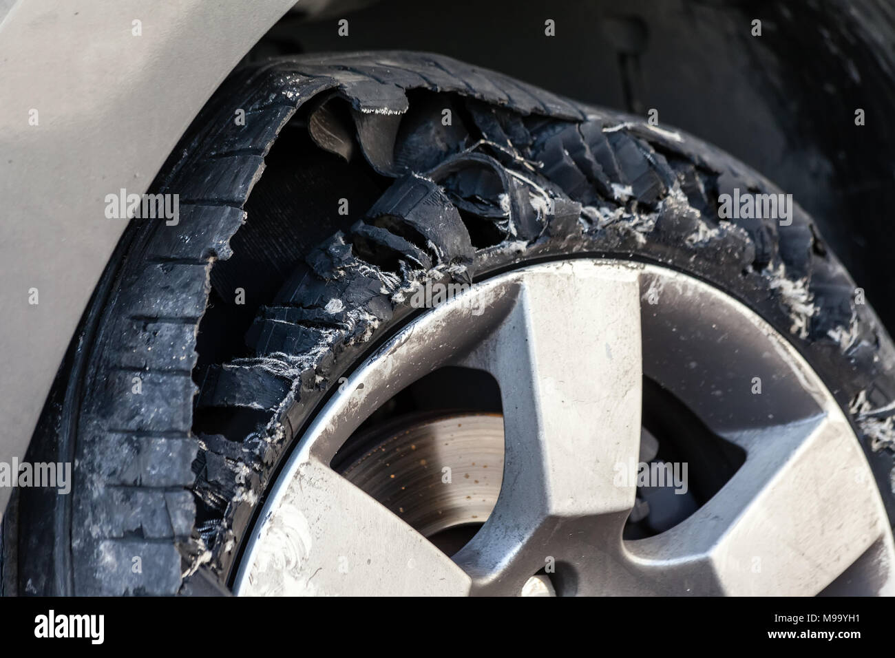 Close up details of a blown out tire with exploded, shredded and ...