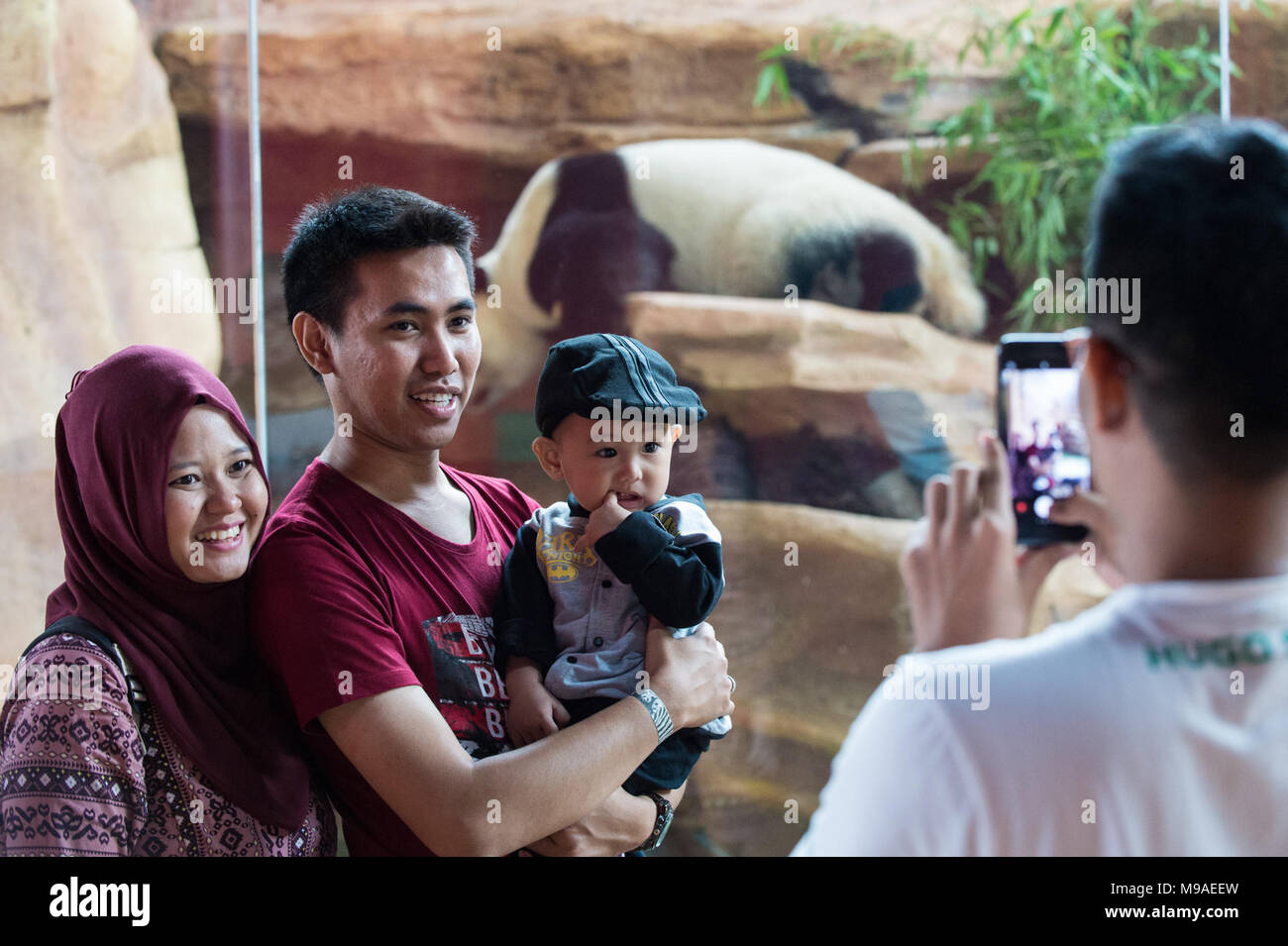 Bogor, Indonesia. 24th Mar, 2018. Tourists pose for photos with the ...