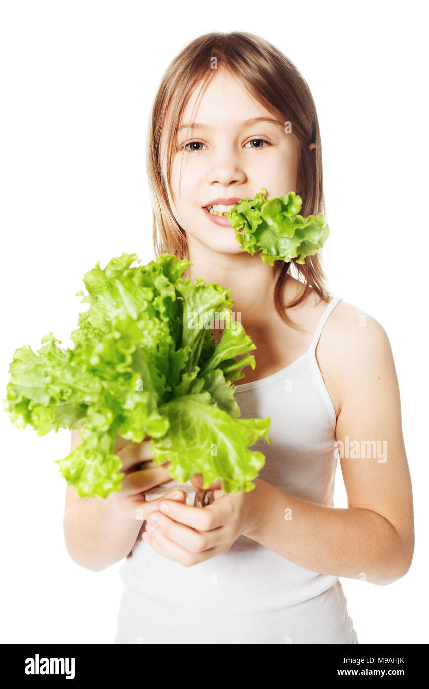 Girl eating lettuce. Portrait of beautiful smiling and happy child girl ...