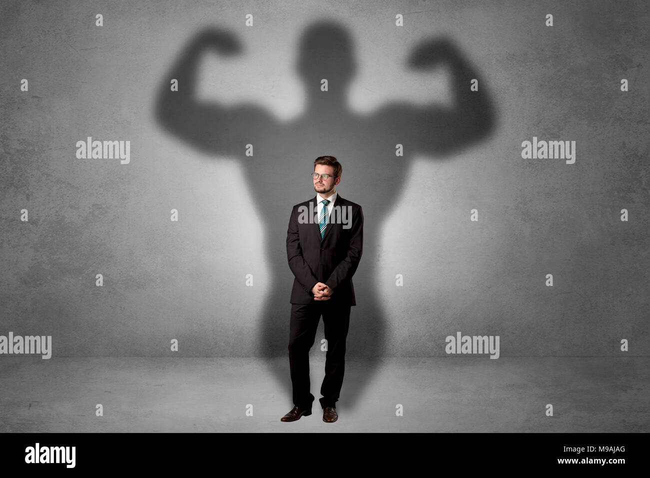 Lovely serious businessman standing with a muscular powerful shadow ...