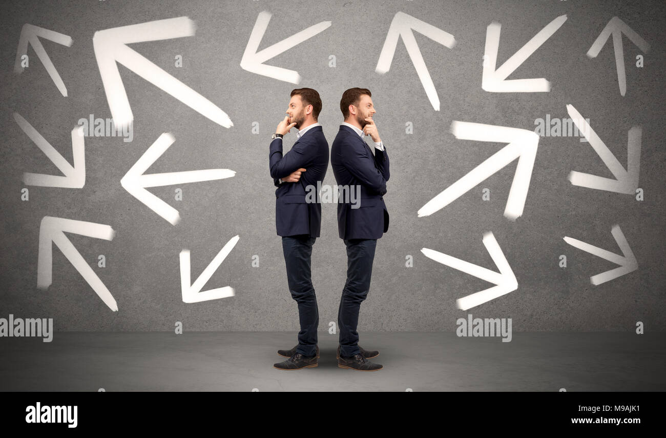 Young conflicted businessman choosing between two directions with ...