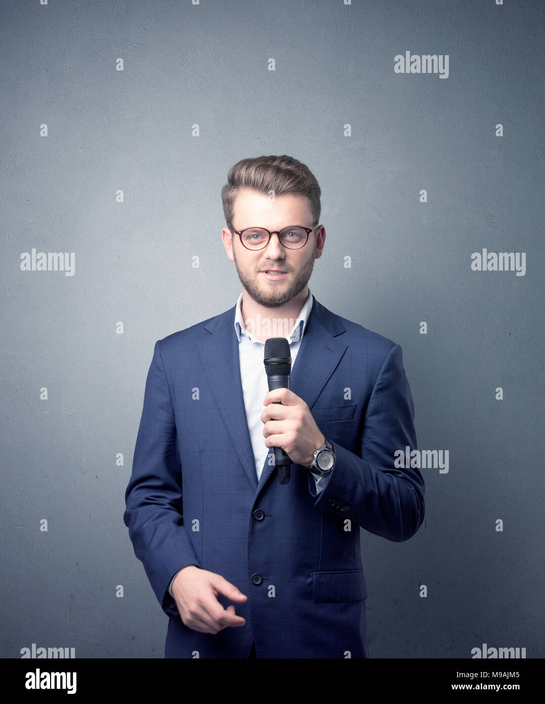 Businessman speaking into microphone with blue background Stock Photo ...