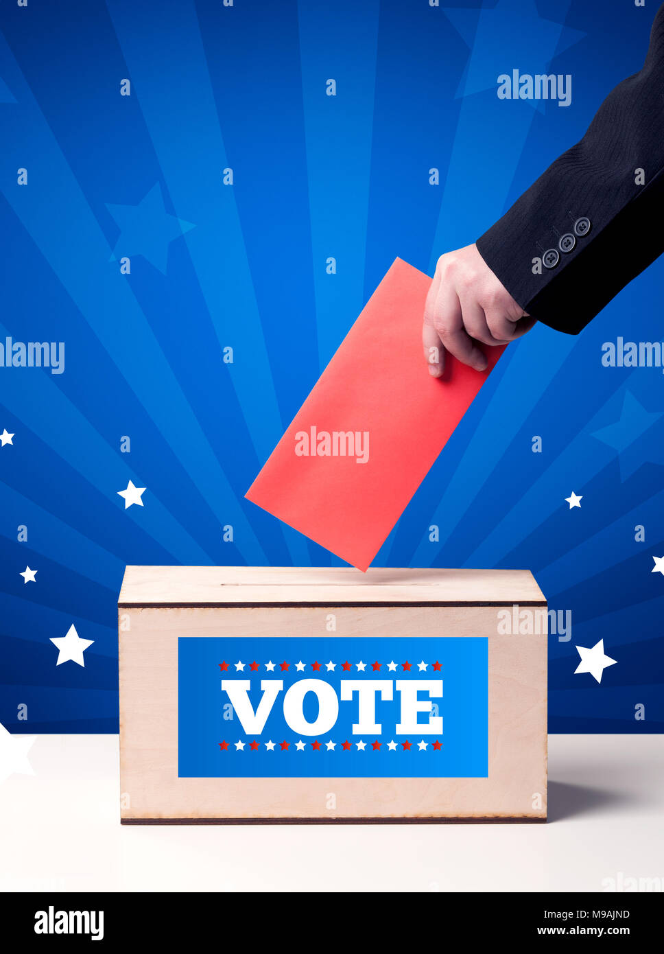 Voting hand with ballot and wooden box Stock Photo - Alamy