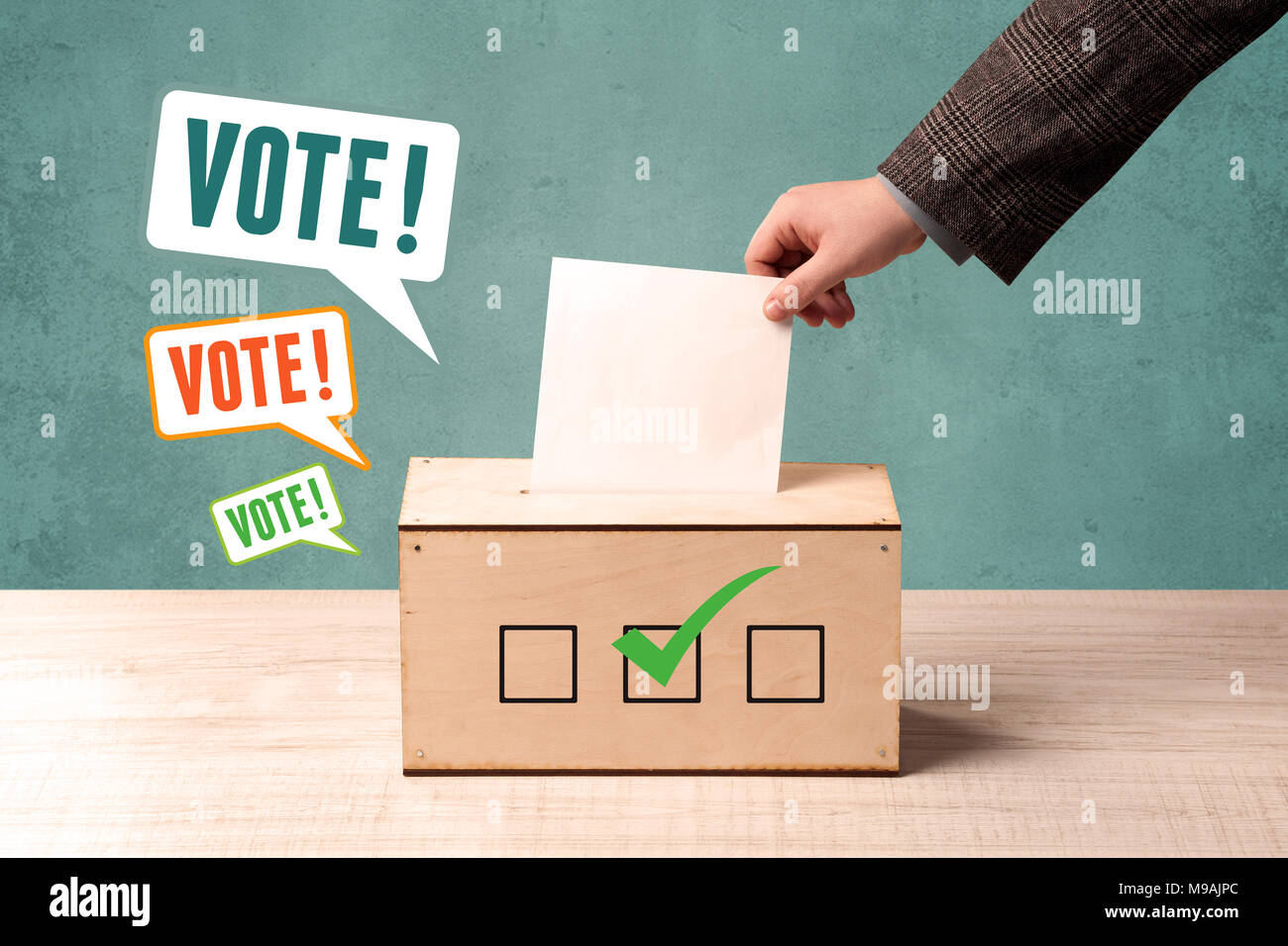 A hand placing a voting slip into a ballot box Stock Photo - Alamy
