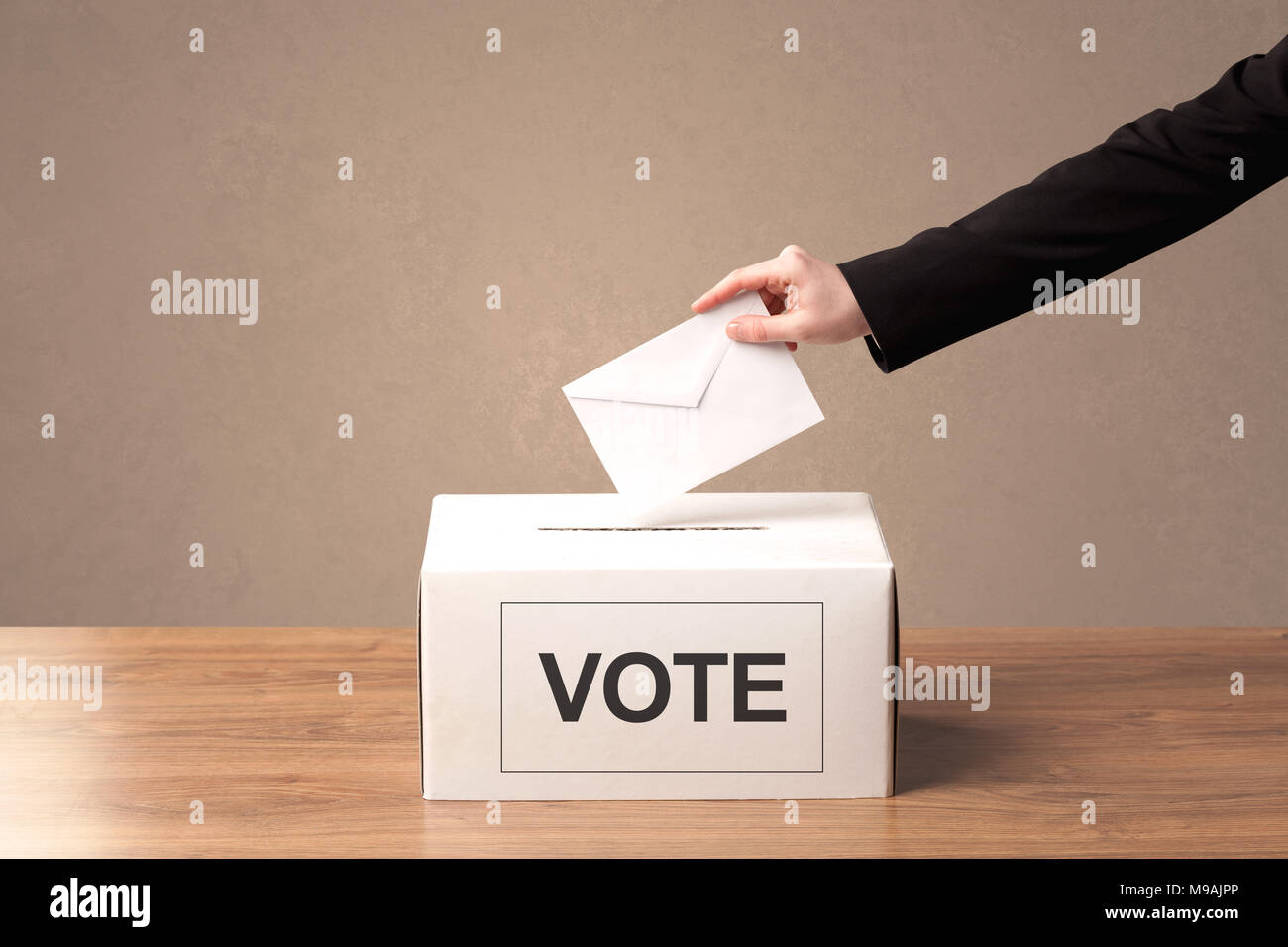 Close up of male hand putting vote into a ballot box, on grungy ...