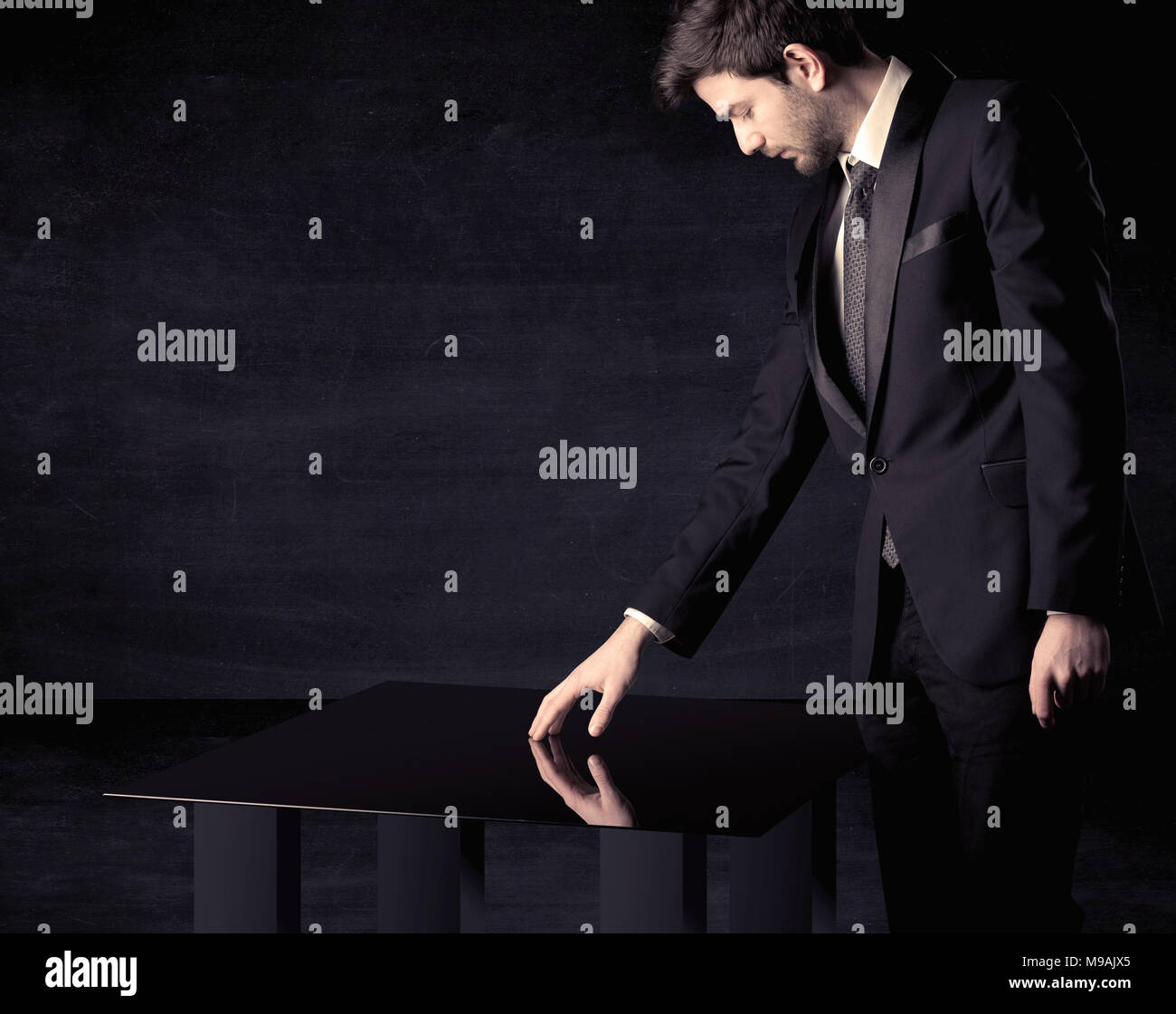 Close up of a hand touching smart table with copy space on black ...