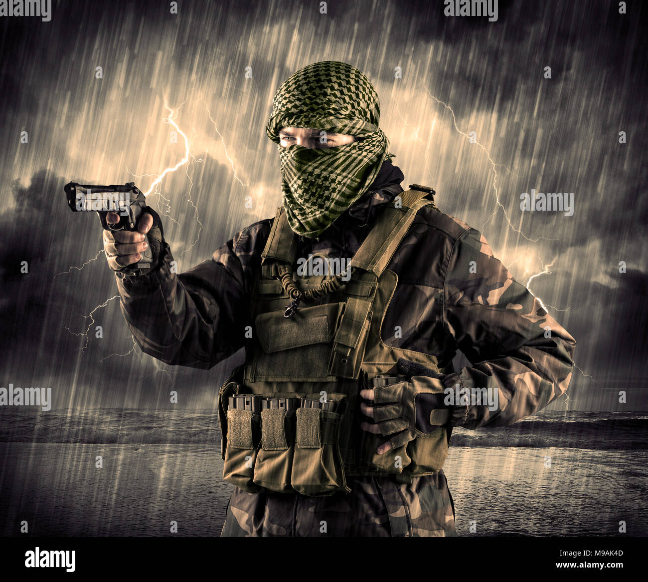 Portrait of a dangerous armed terrorist with mask and gun in a ...
