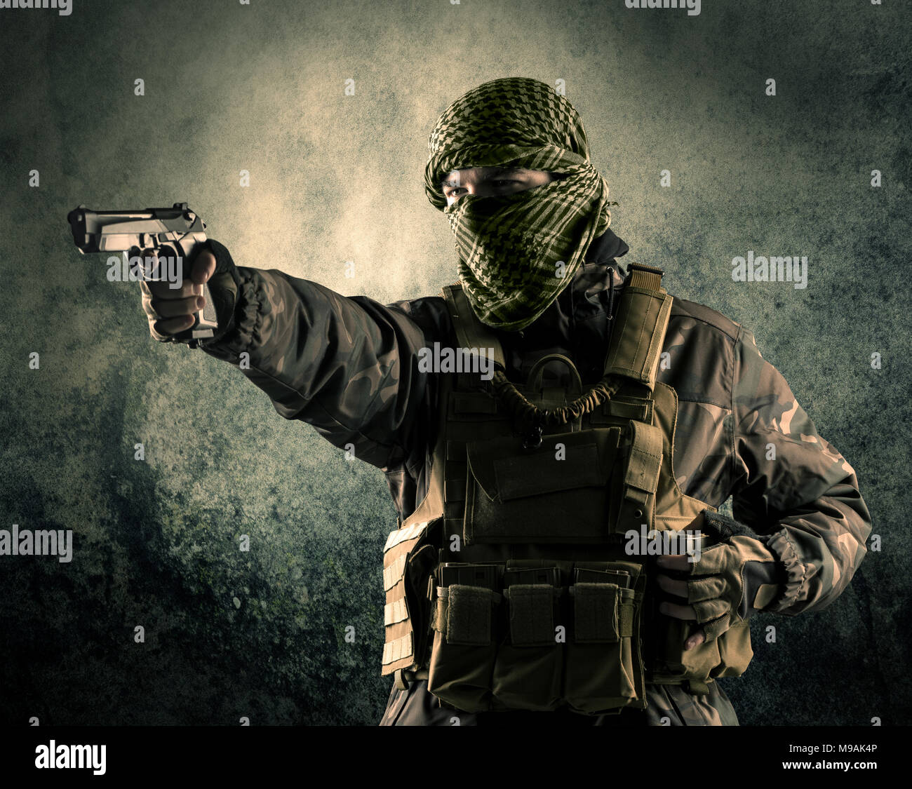 Portrait of a heavily armed masked soldier with grungy background ...