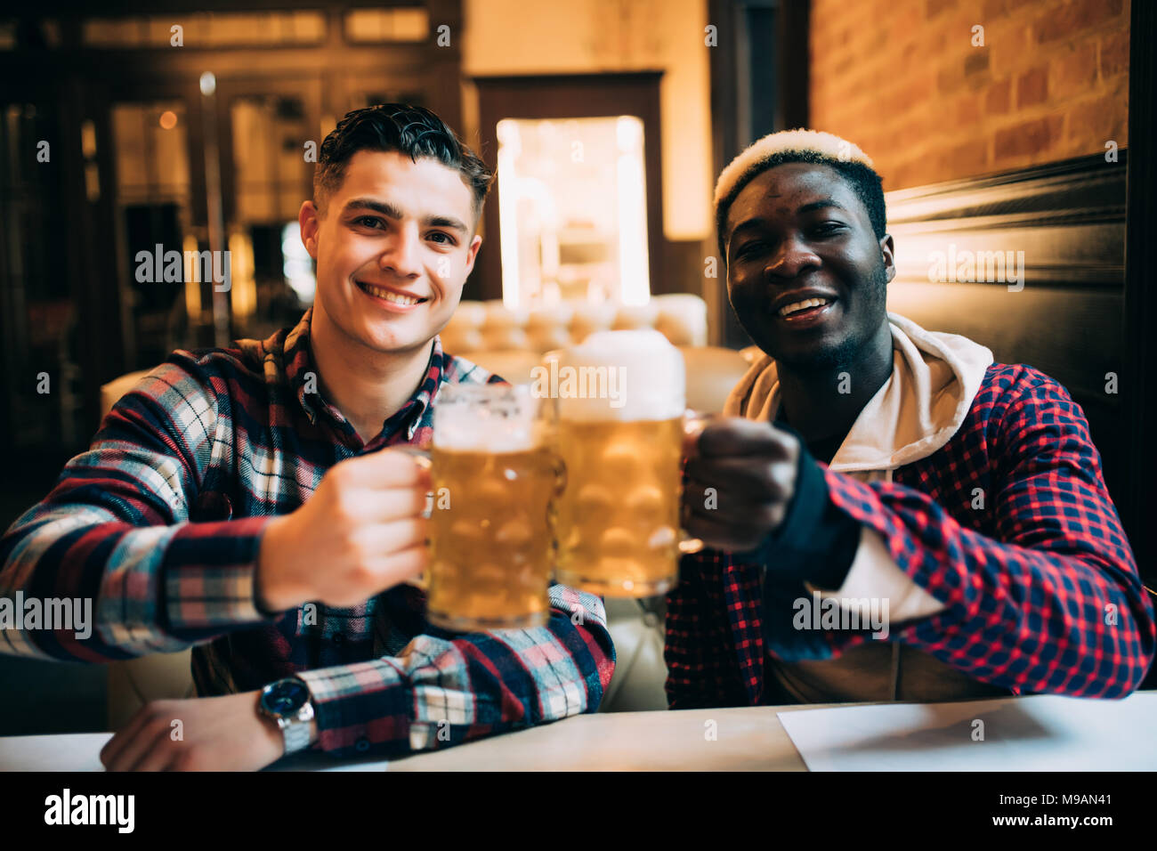 Close up of a two happy male friends drinking beer at pub Stock Photo ...