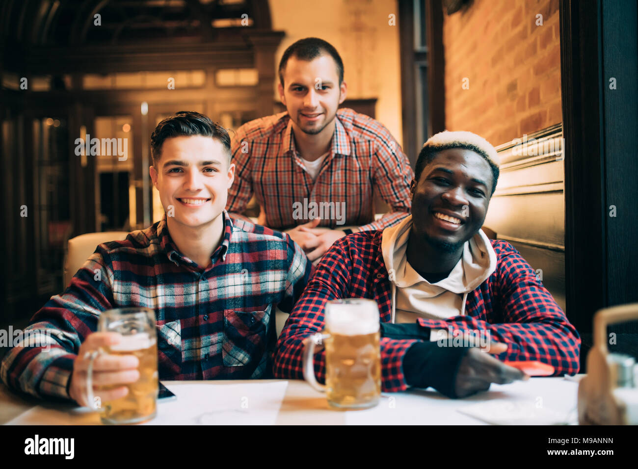 Multiracial Friends Group Drinking And Toasting Beer At Pub Young