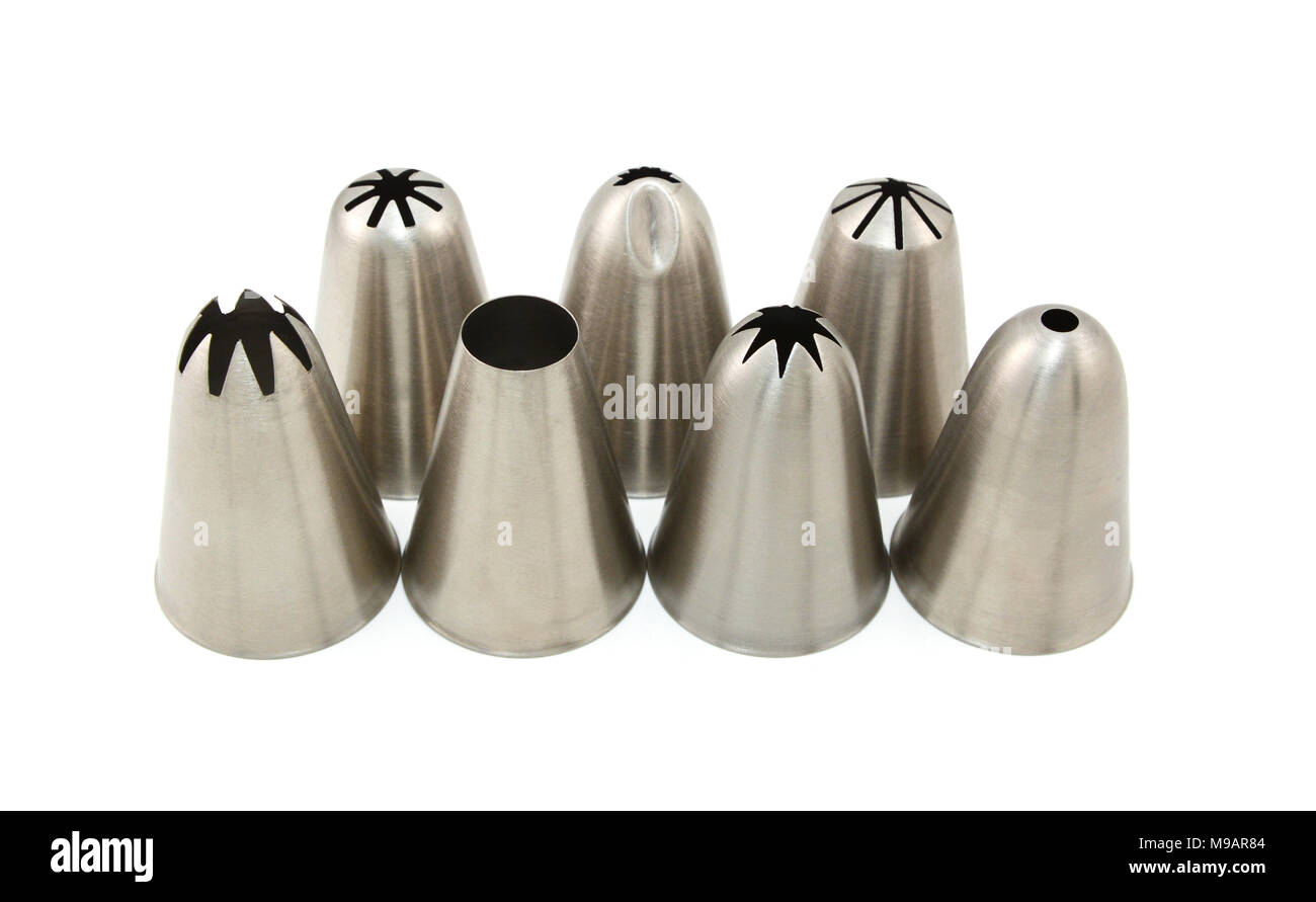 Seven metal icing nozzles for piping different shapes, arranged in two ...