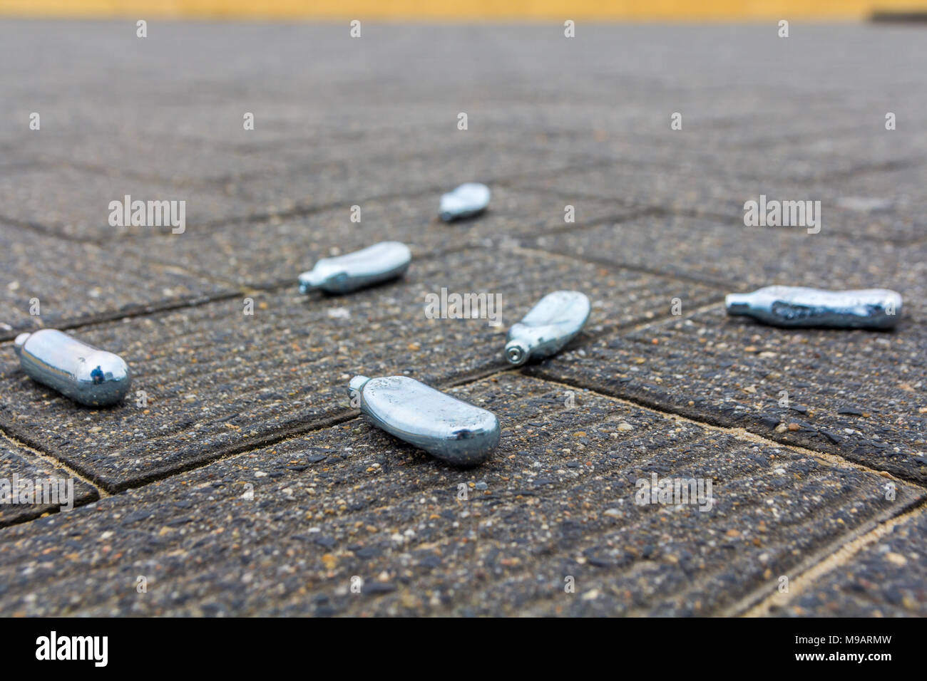 empty nitrous oxide bulbs lying scattered on the street, also known as ...