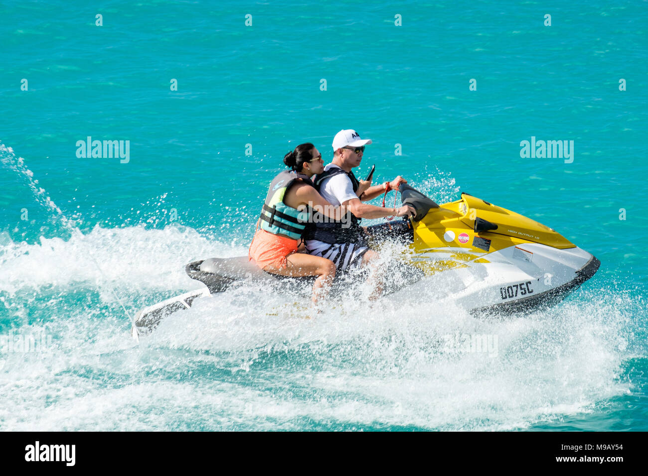 Tourist couple on jet ski, Cocobay, Antigua Stock Photo - Alamy