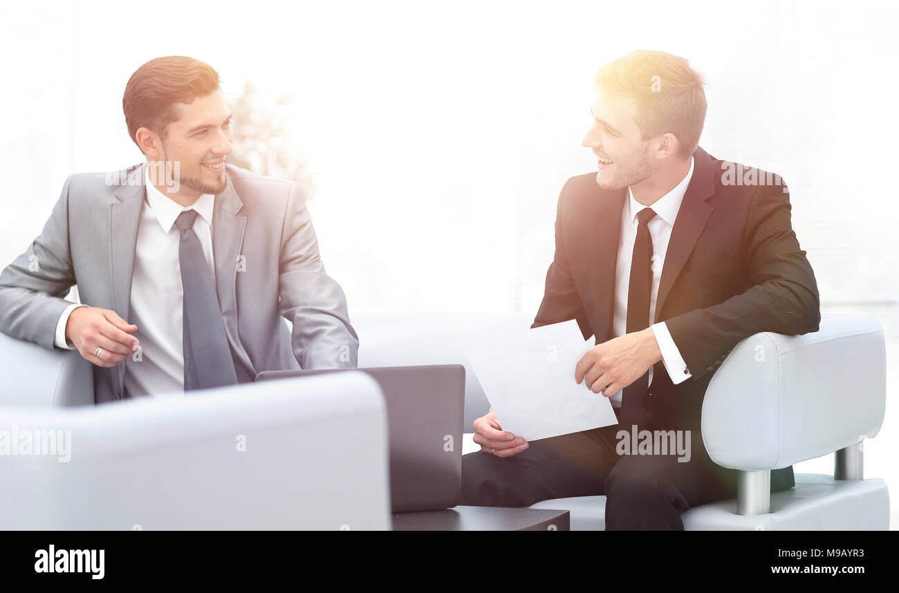 employees talking, sitting the lobby of the office Stock Photo - Alamy