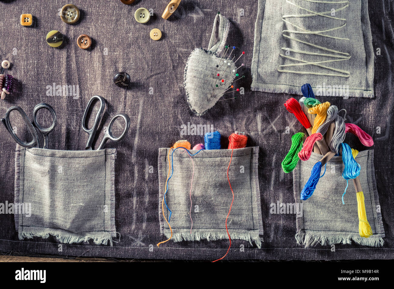 Colored thread, scissors and buttons in tailor mat Stock Photo - Alamy